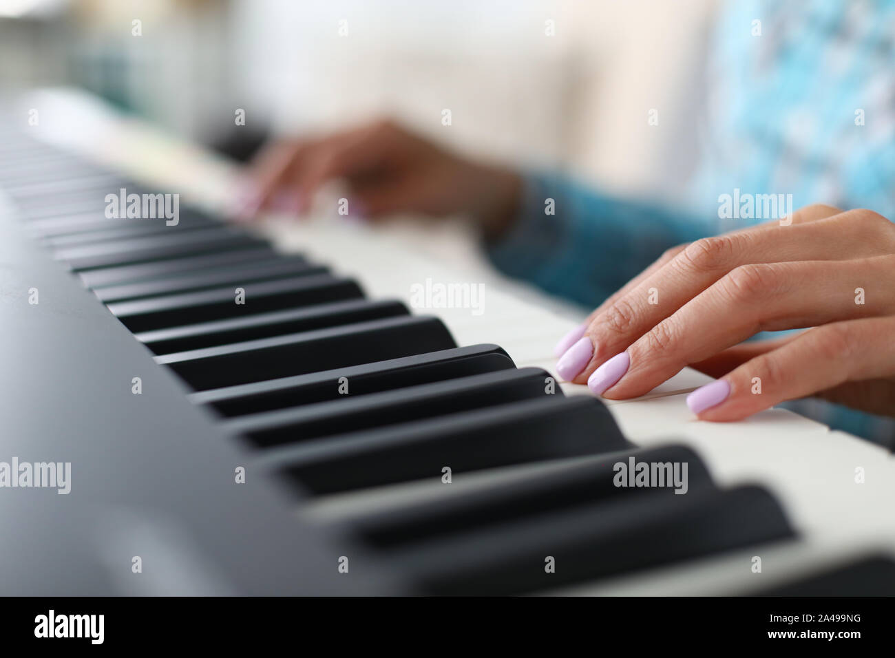 Pretty woman giving lesson to play piano Stock Photo - Alamy