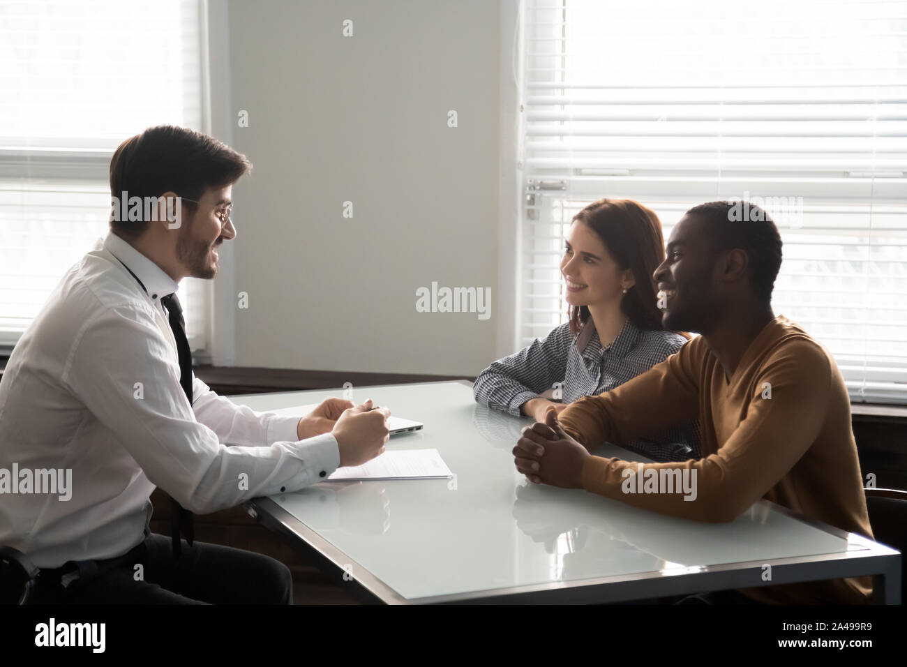 Bank worker explaining contract details for clients Stock Photo - Alamy