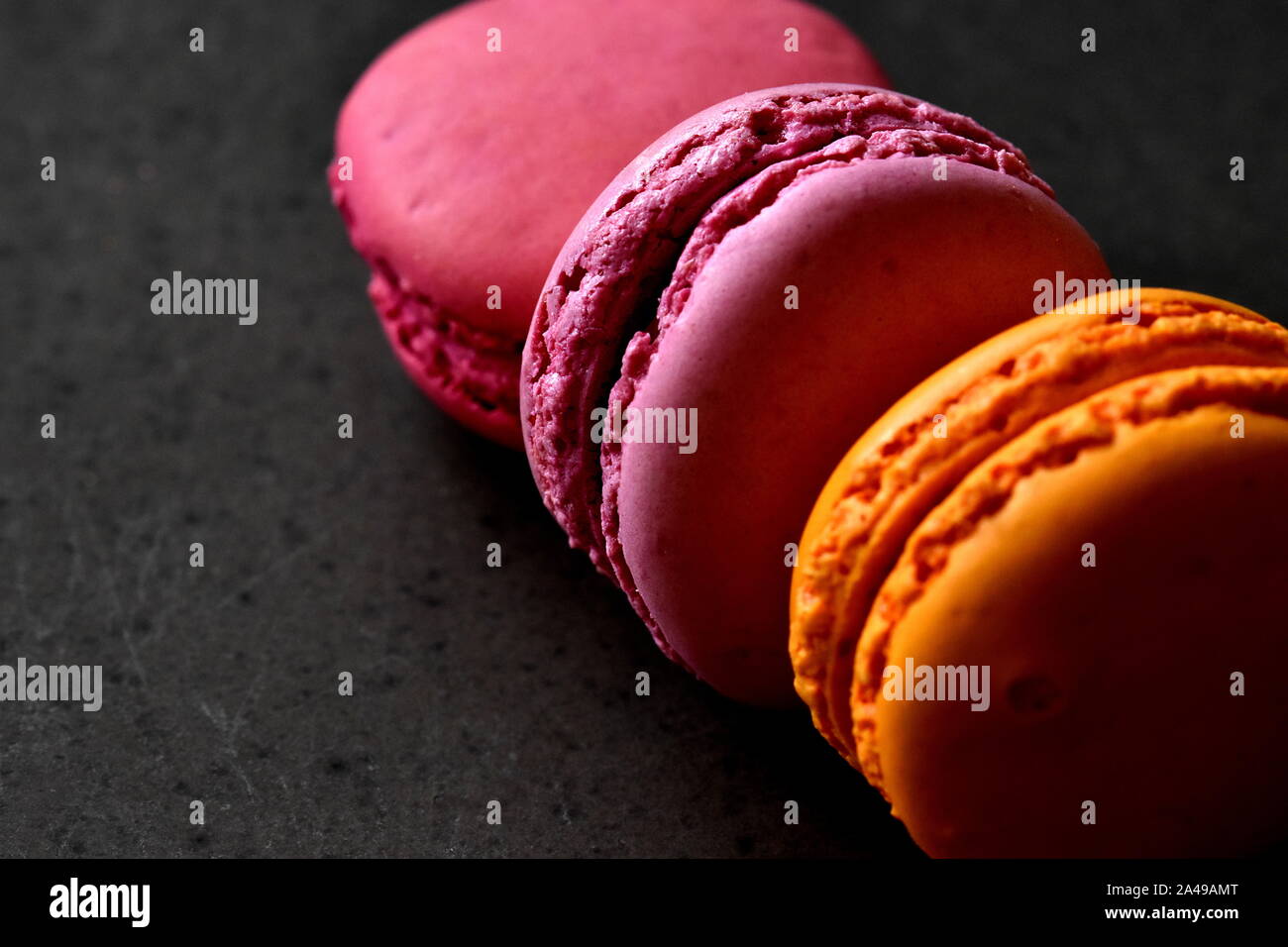 Colorful sweet cookies background with copy space. Three macarons or ...