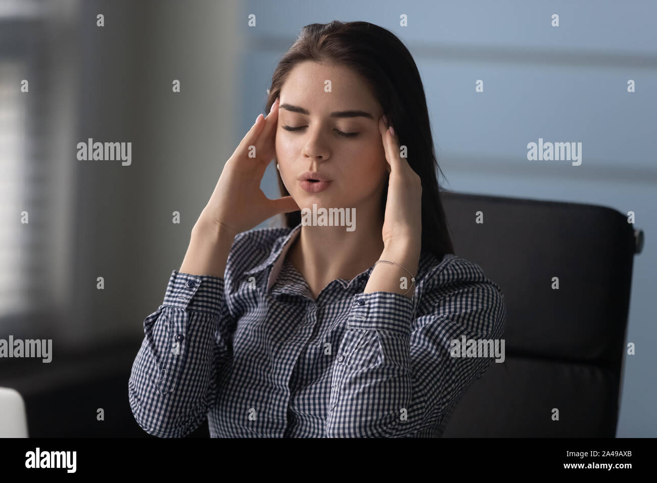 Stressed woman massaging temples, trying control work pressure at ...