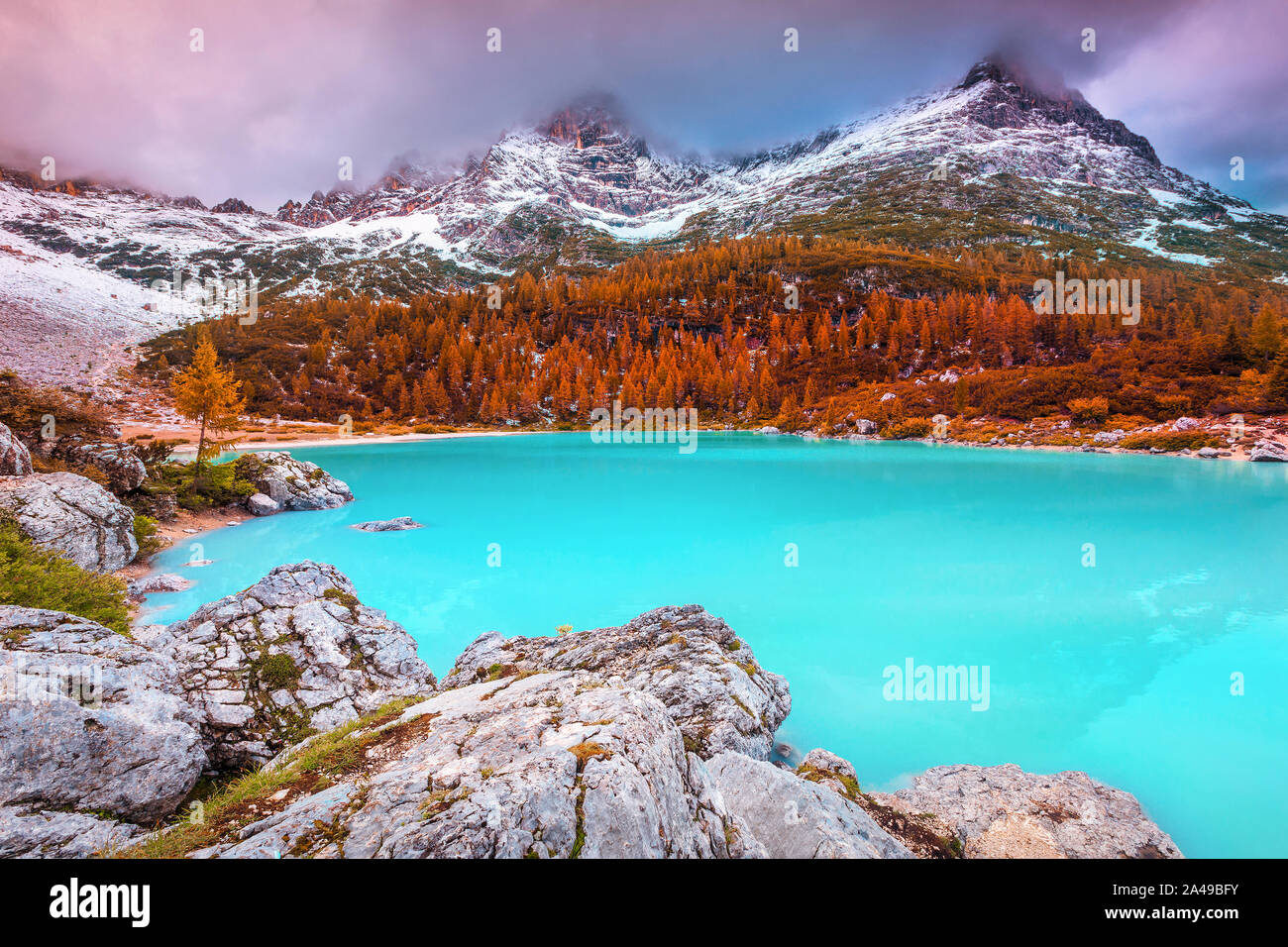 Snowy misty mountains at colorful sunset. Popular touristic and hiking ...
