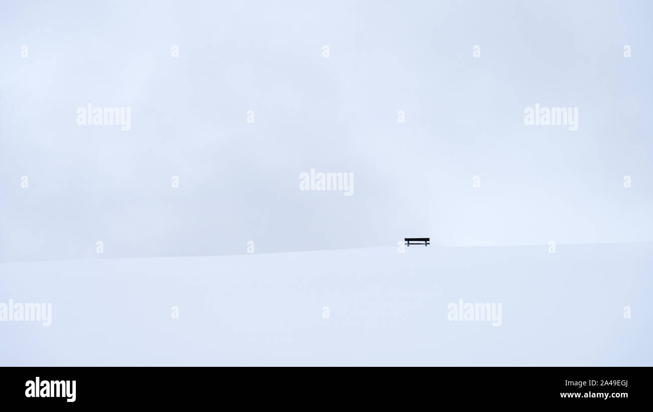 Empty lonely bench far away in white winter landscape Stock Photo - Alamy