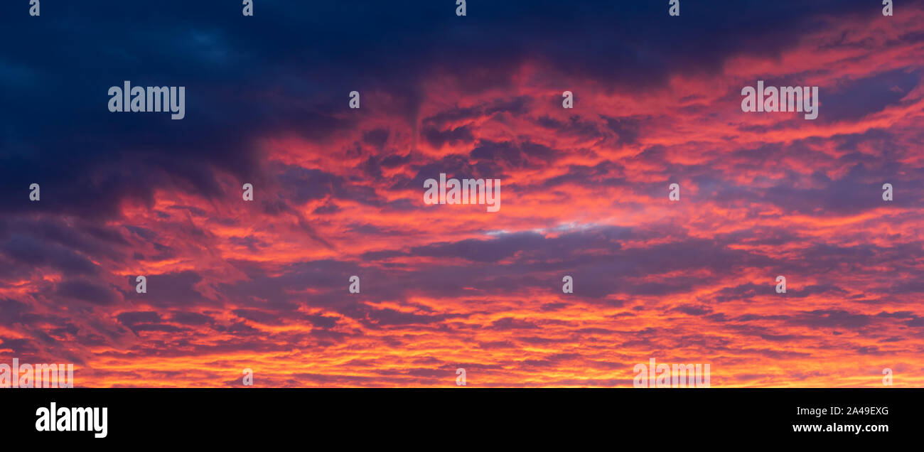 Fiery red clouds, light rays and other atmospheric effect at sunset or ...