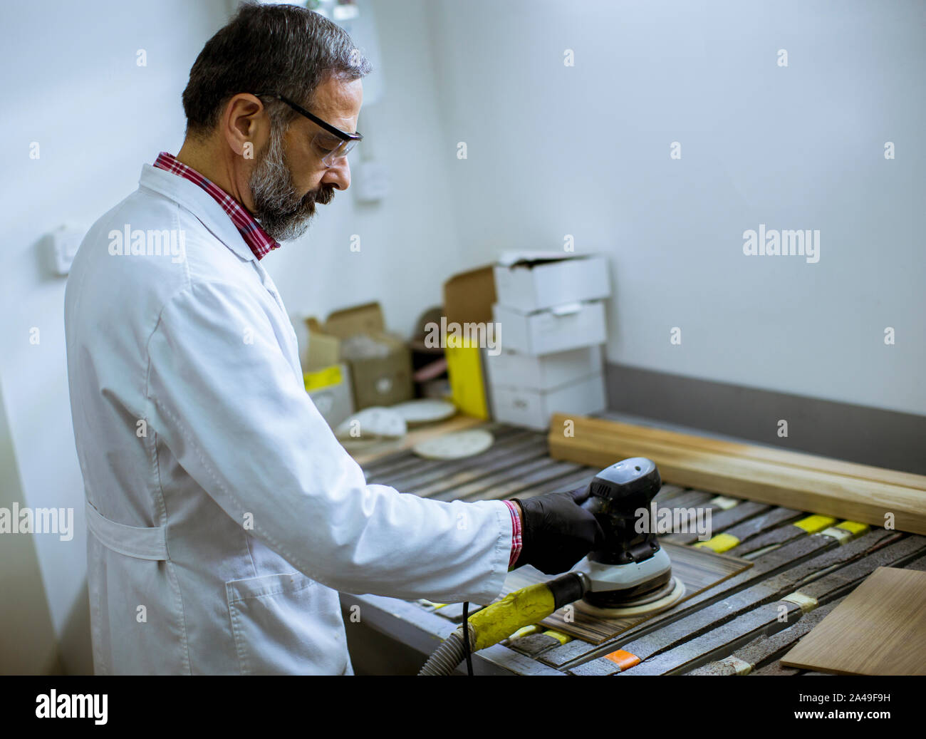View at handsome senior engineer in the laboratory examines ceramic ...