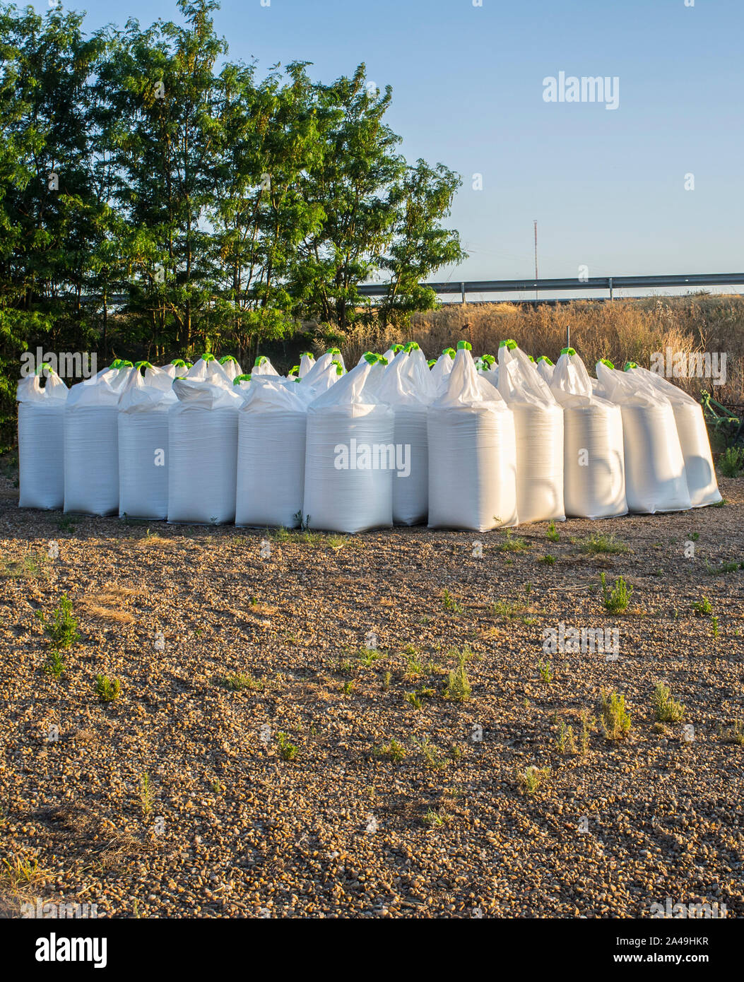 Stacks of raffia fertilizer sacks stacked over ground. Agricultural ...