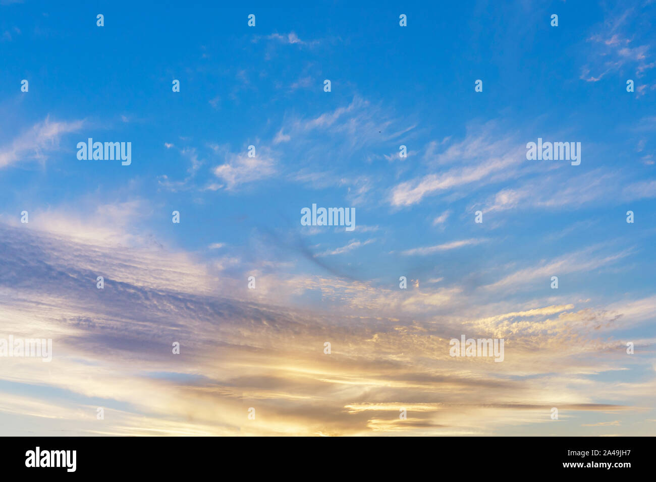 beautiful blue sunset sky. feather clouds, orange light Stock Photo - Alamy