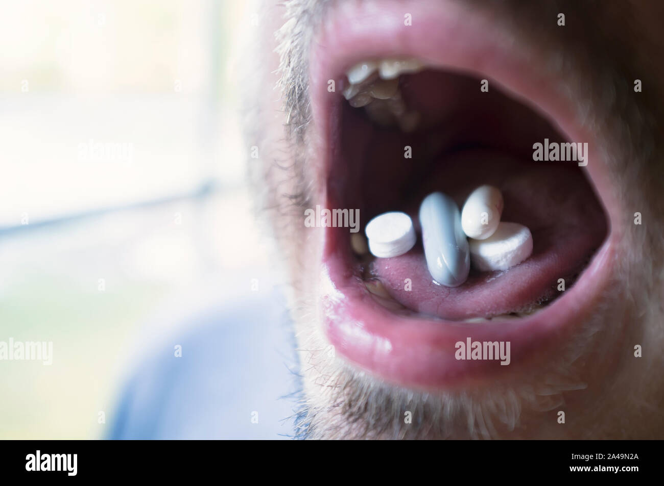 Tablets of several colors, sizes and shapes on the tongue, in the mouth ...