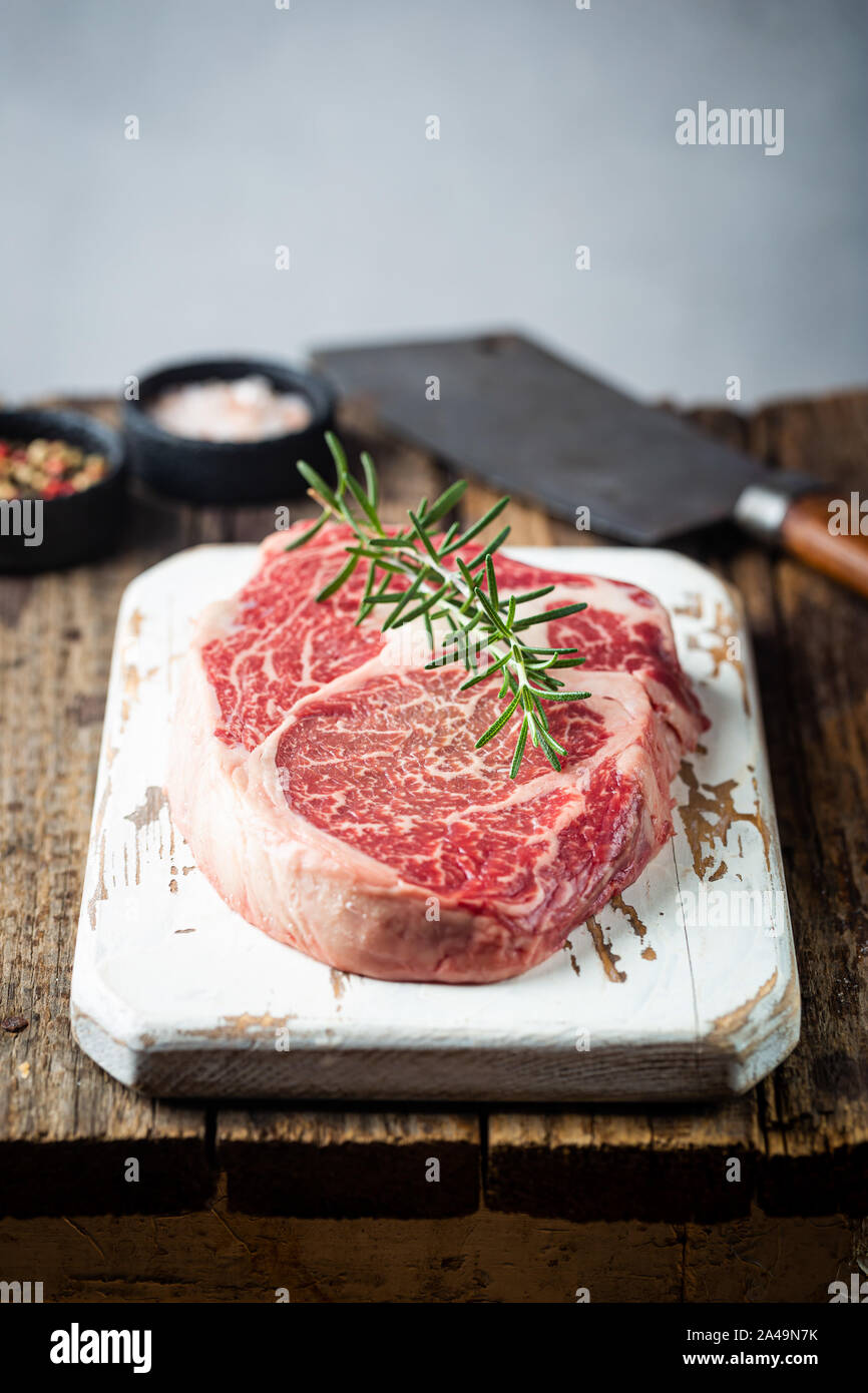 Raw fresh meat Ribeye Steak and seasonings on wooden background, rustic ...