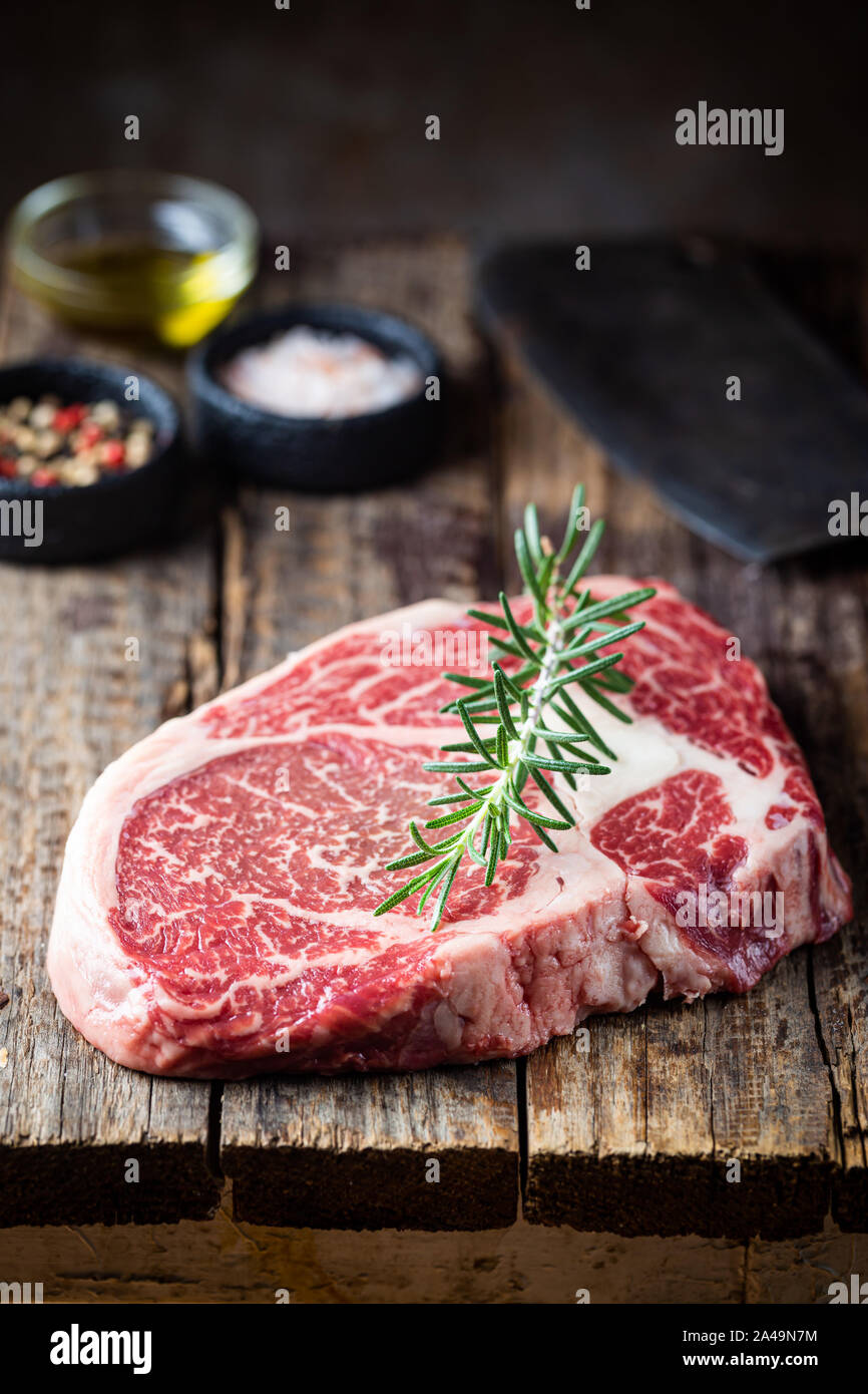 Raw fresh meat Ribeye Steak and seasonings on wooden background, rustic ...