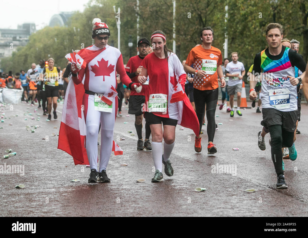 London, UK, 13 October 2019. Runners on The Mall draped in the Canadian ...