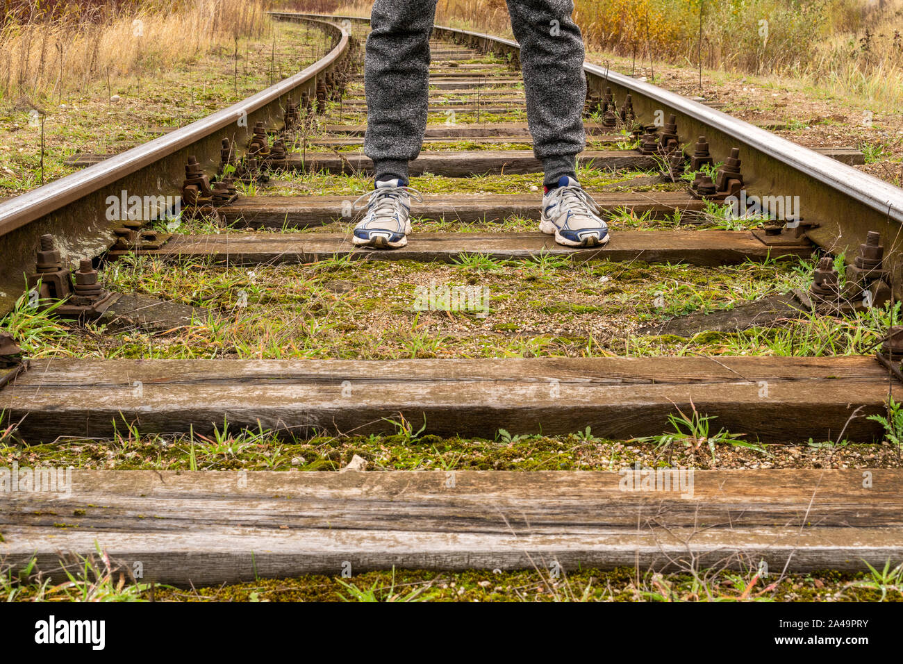 Man walking along railway. Legs of traveler on rail tracks Stock Photo ...