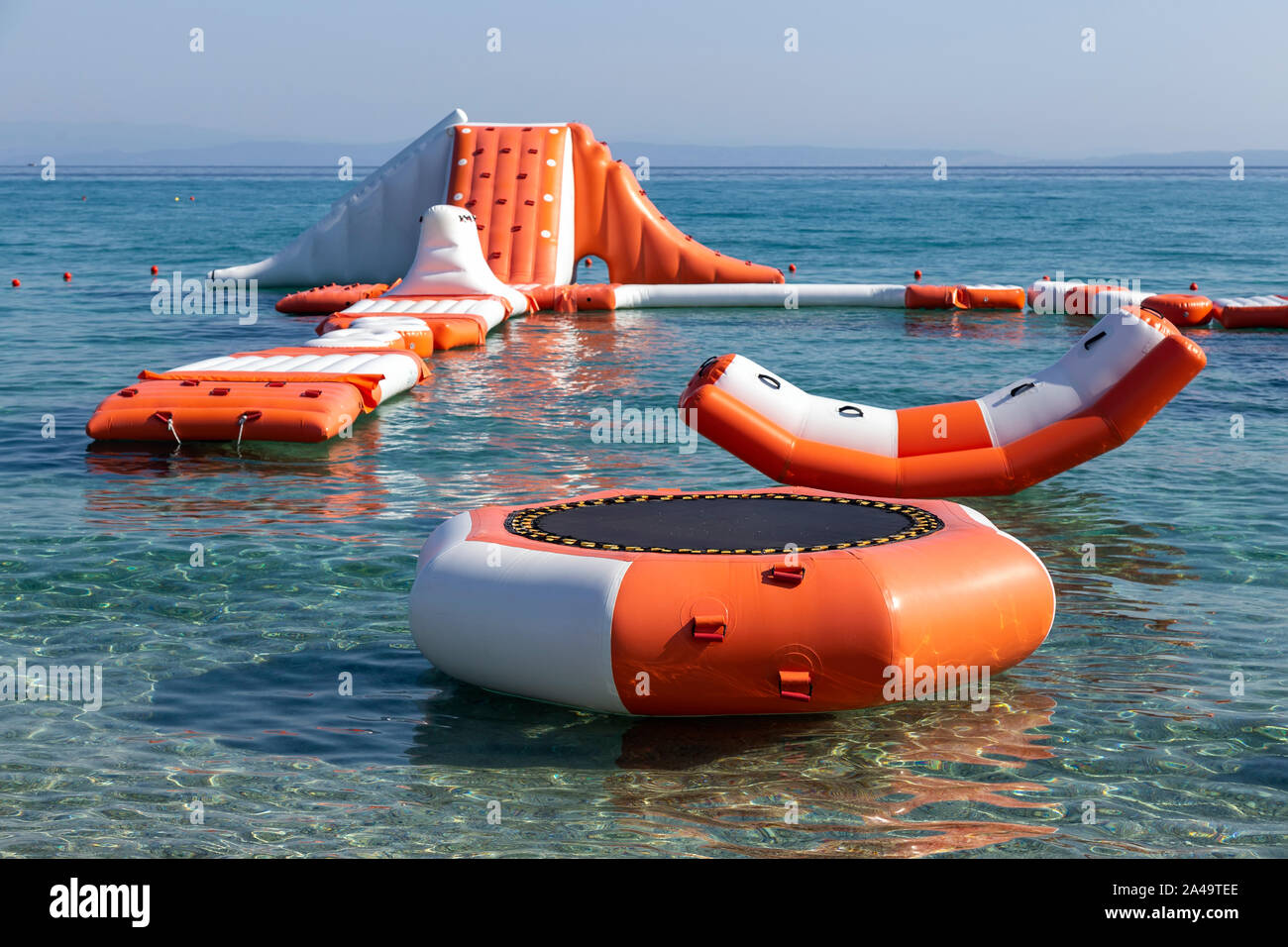 Inflatable floating water park. Water outdoor bouncy park, floating ...