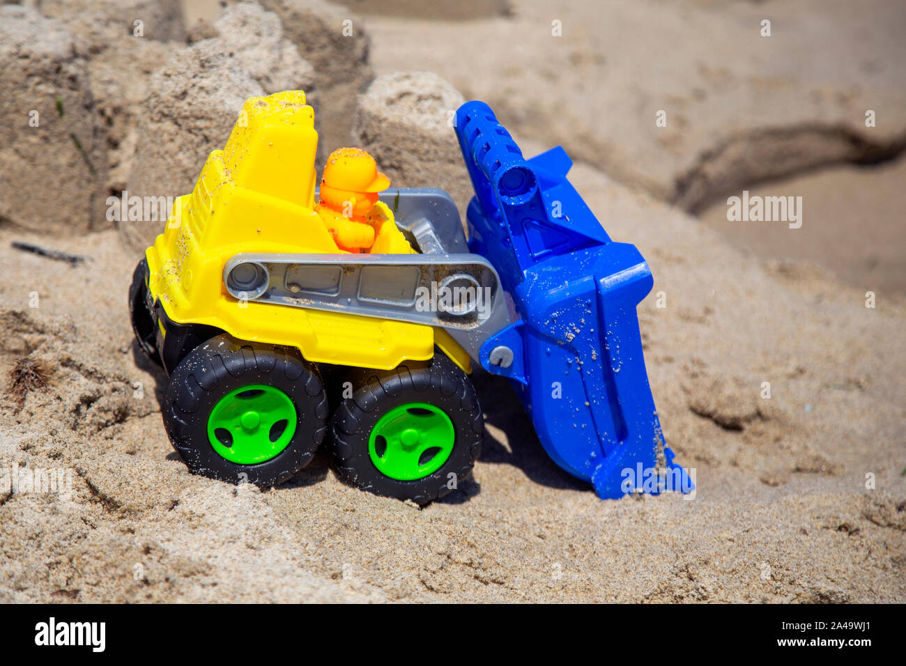 Wheel dozer plastic toy at the sea beach, yellow dozer construction ...