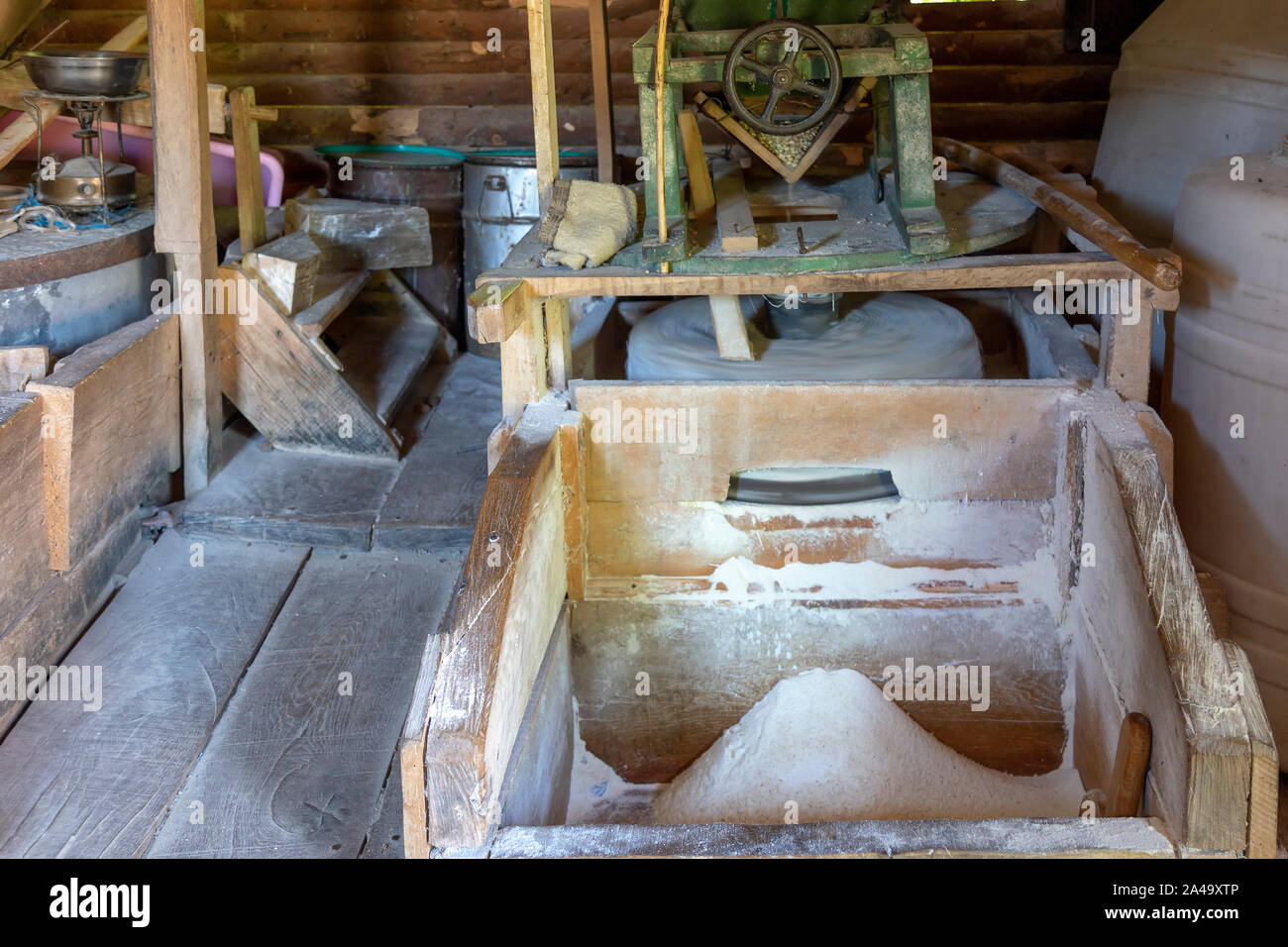 Old fashioned mill for grinding corn to flour. Water from a river flows ...