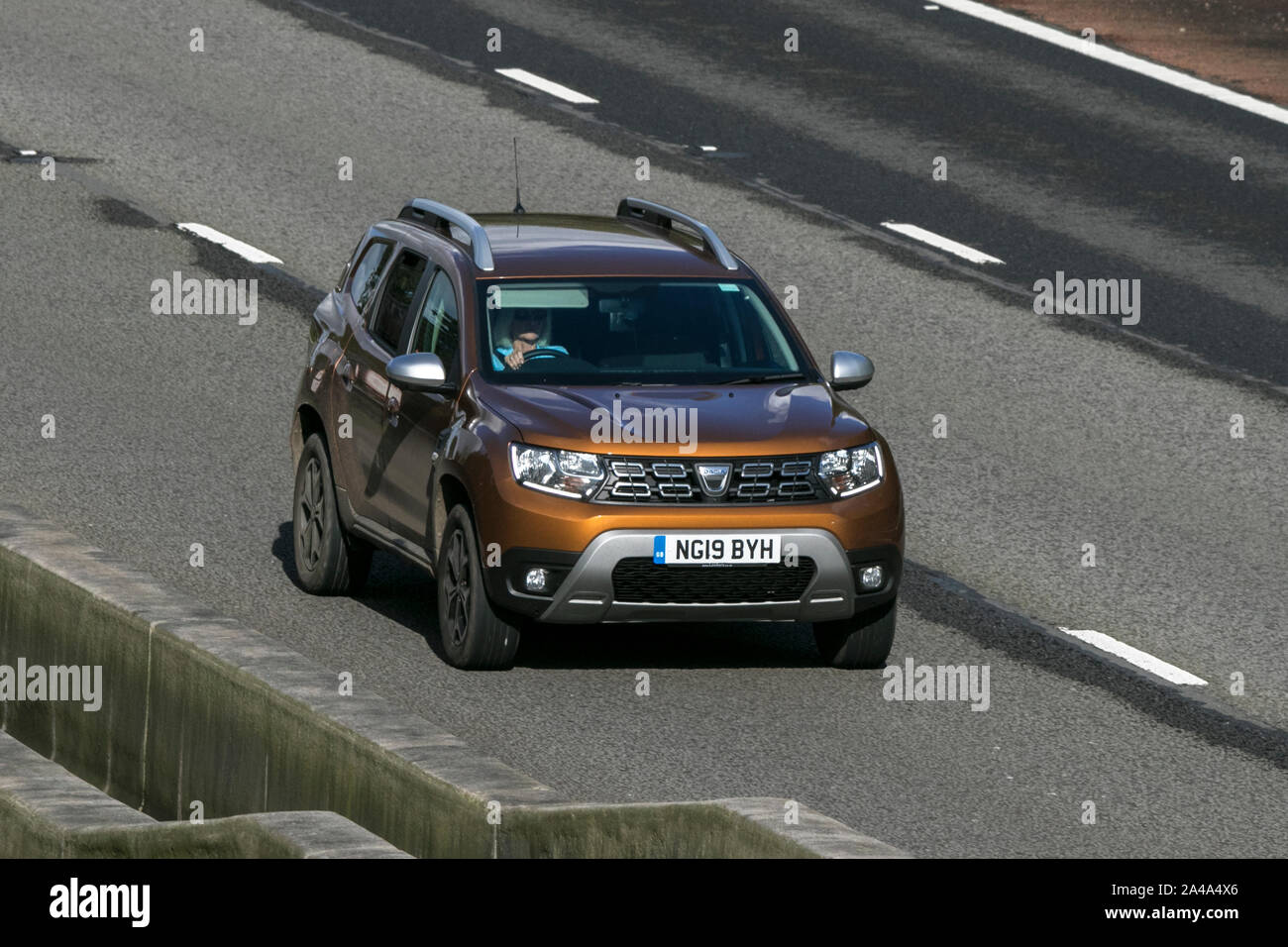 2019 orange Dacia Duster Prestige SCE 4X4; traveling on the M6 motorway ...
