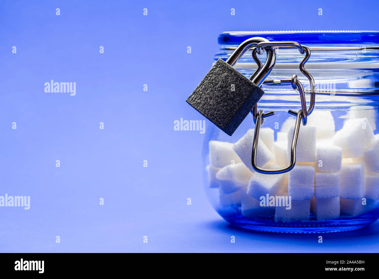 White sugar cubes in a transparent glass jar with a lid, which for ...