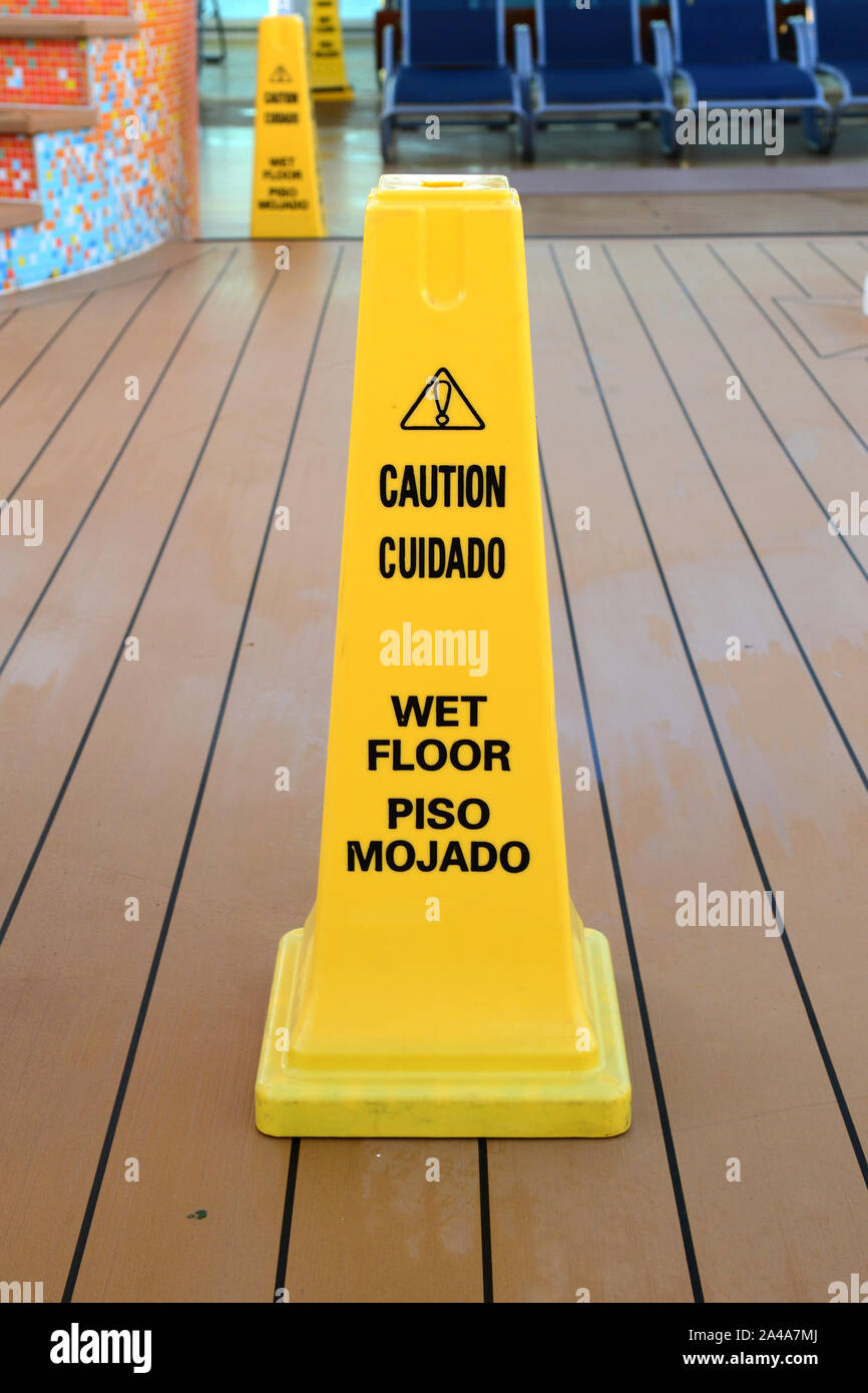 Yellow Caution Wet Floor safety pylon on a cruise ship Stock Photo - Alamy