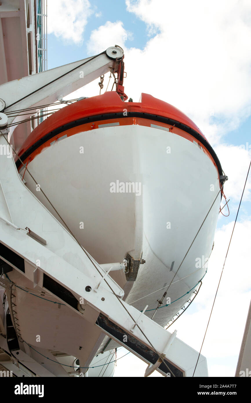 Cruise ship's lifeboat hanging by a tender off the side of the ship ...