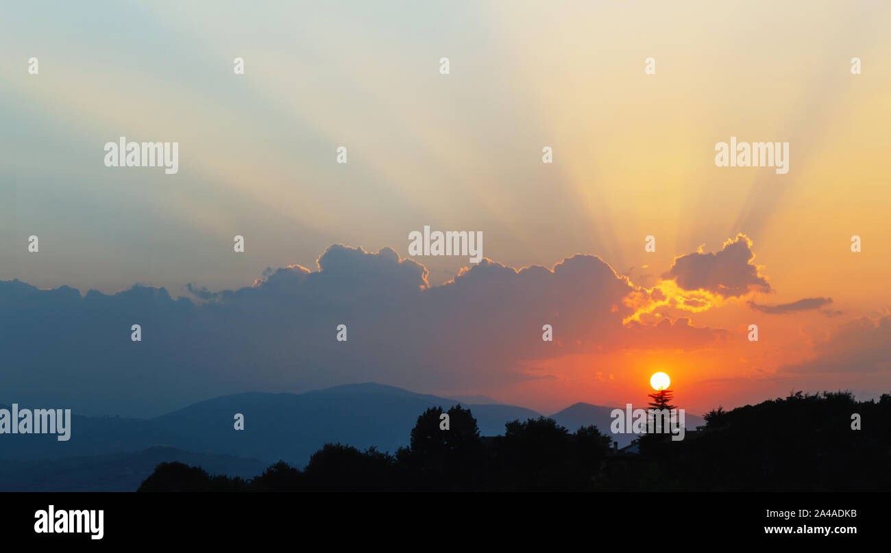 Landscape at twilight, dramatic sunset, cloudy weather with sunlight ...