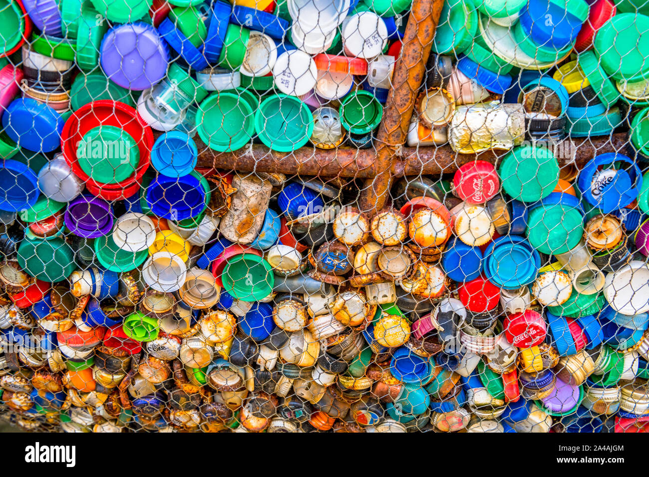 Large colection of coloured plastic and metal bottle tops forming a ...