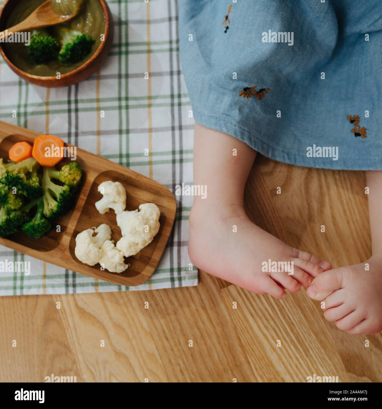 legs little girl and a plate with vegetable Stock Photo - Alamy