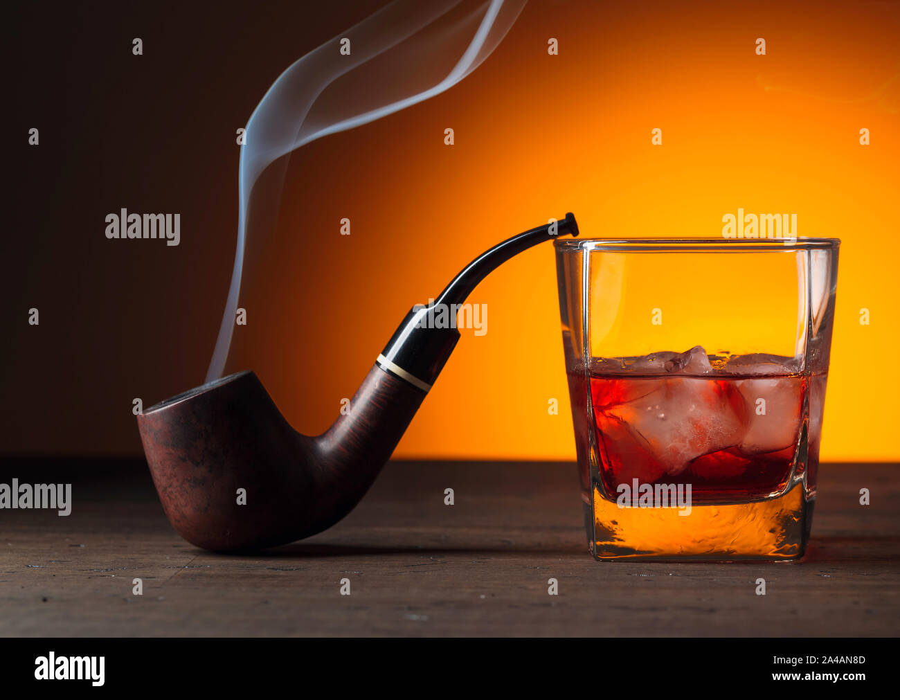 Whiskey with natural ice and smoking pipe with a smoke Stock Photo - Alamy