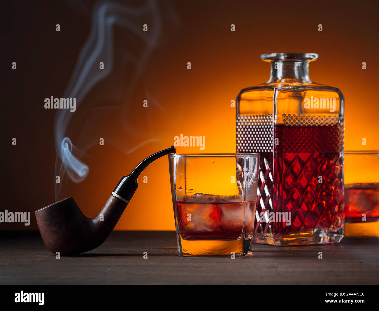Whiskey with natural ice and smoking pipe with a smoke Stock Photo - Alamy