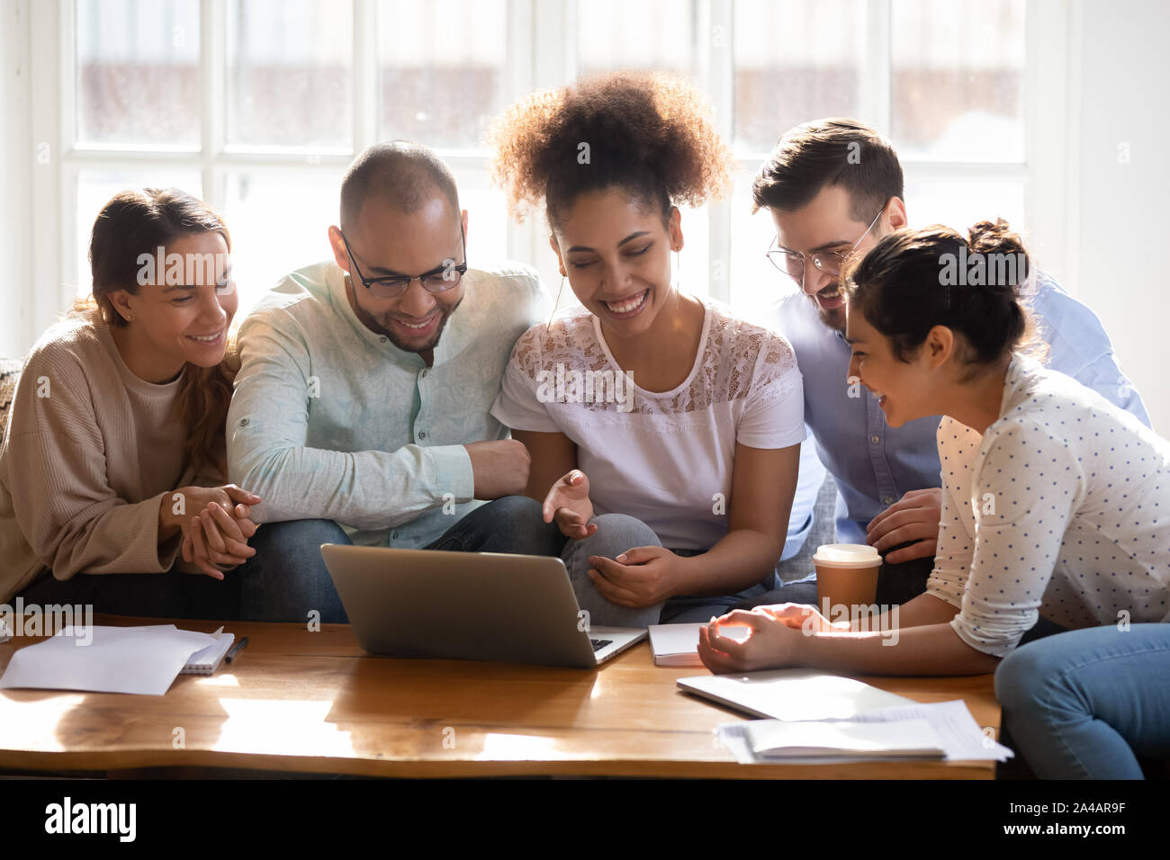 Happy diverse friends using laptop together, looking at screen Stock ...