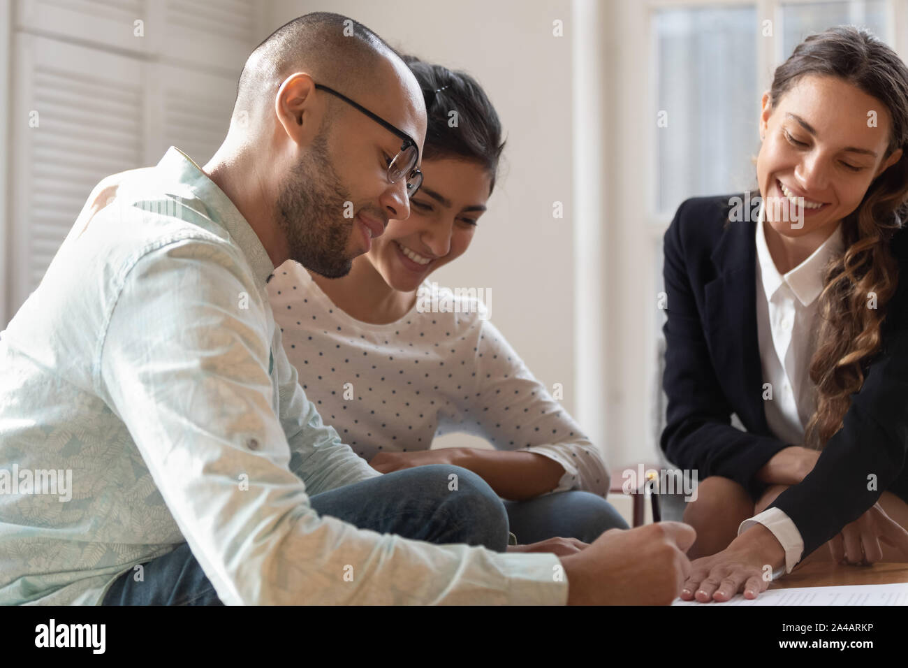 Happy diverse couple signing documents, making successful deal Stock ...