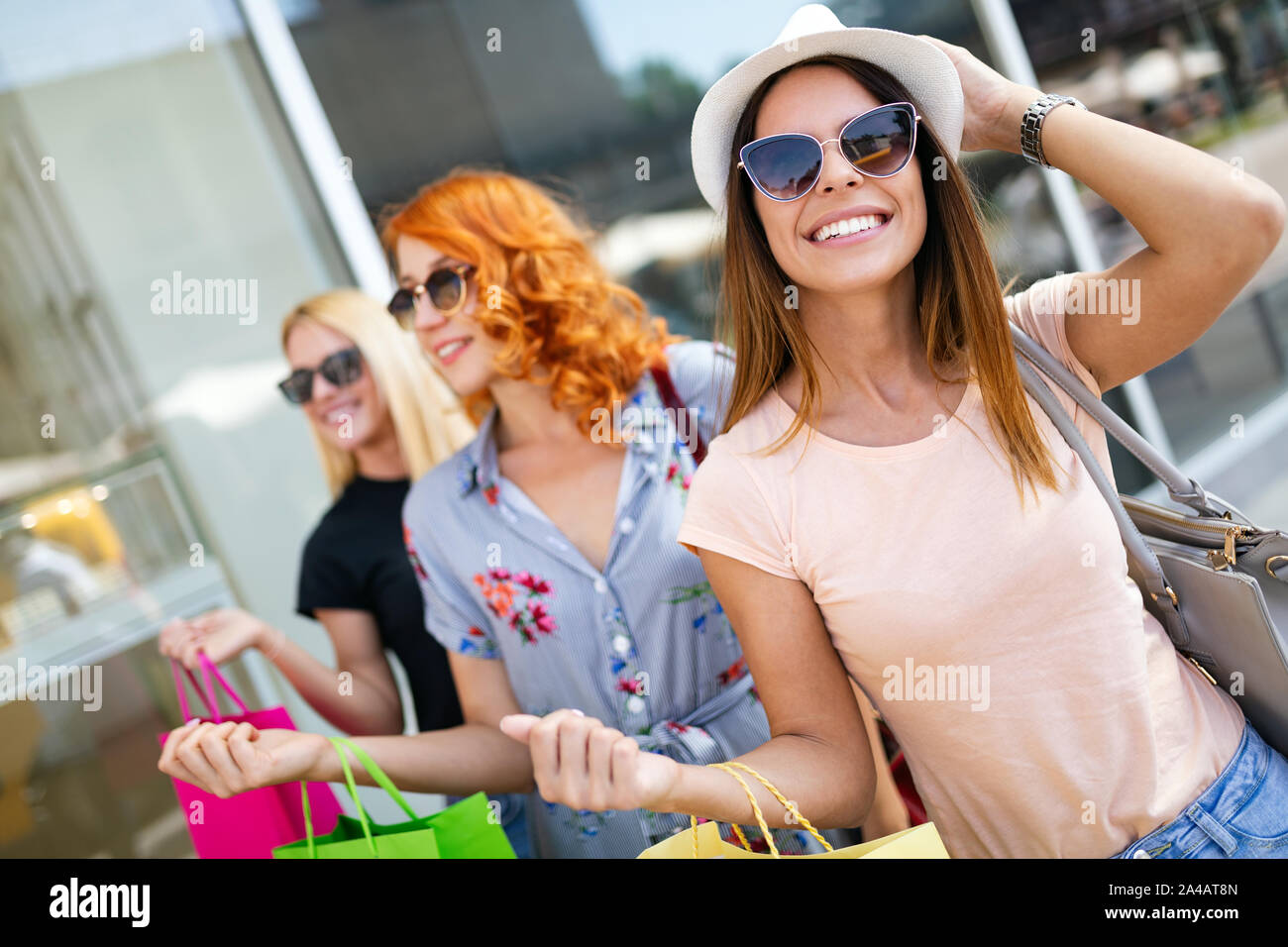 Women friends with shopping bags having fun while shopping in a mall ...