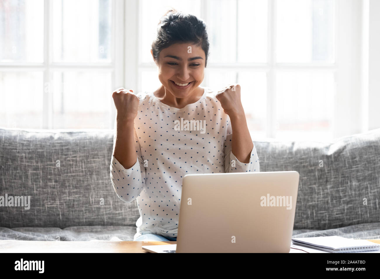 Excited Indian woman celebrating win, looking at laptop screen Stock ...