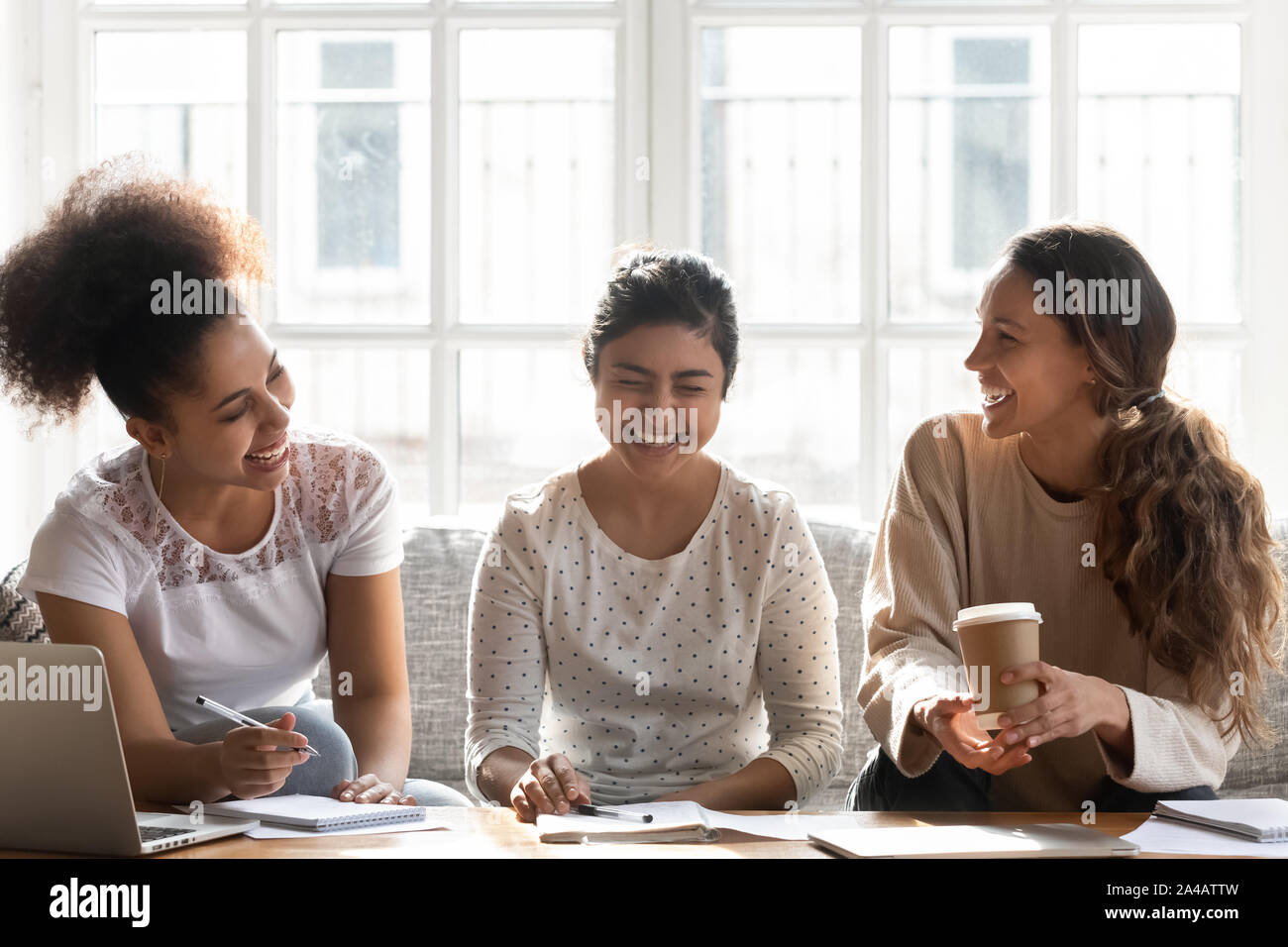 Happy diverse girls having fun, studying together at home Stock Photo ...