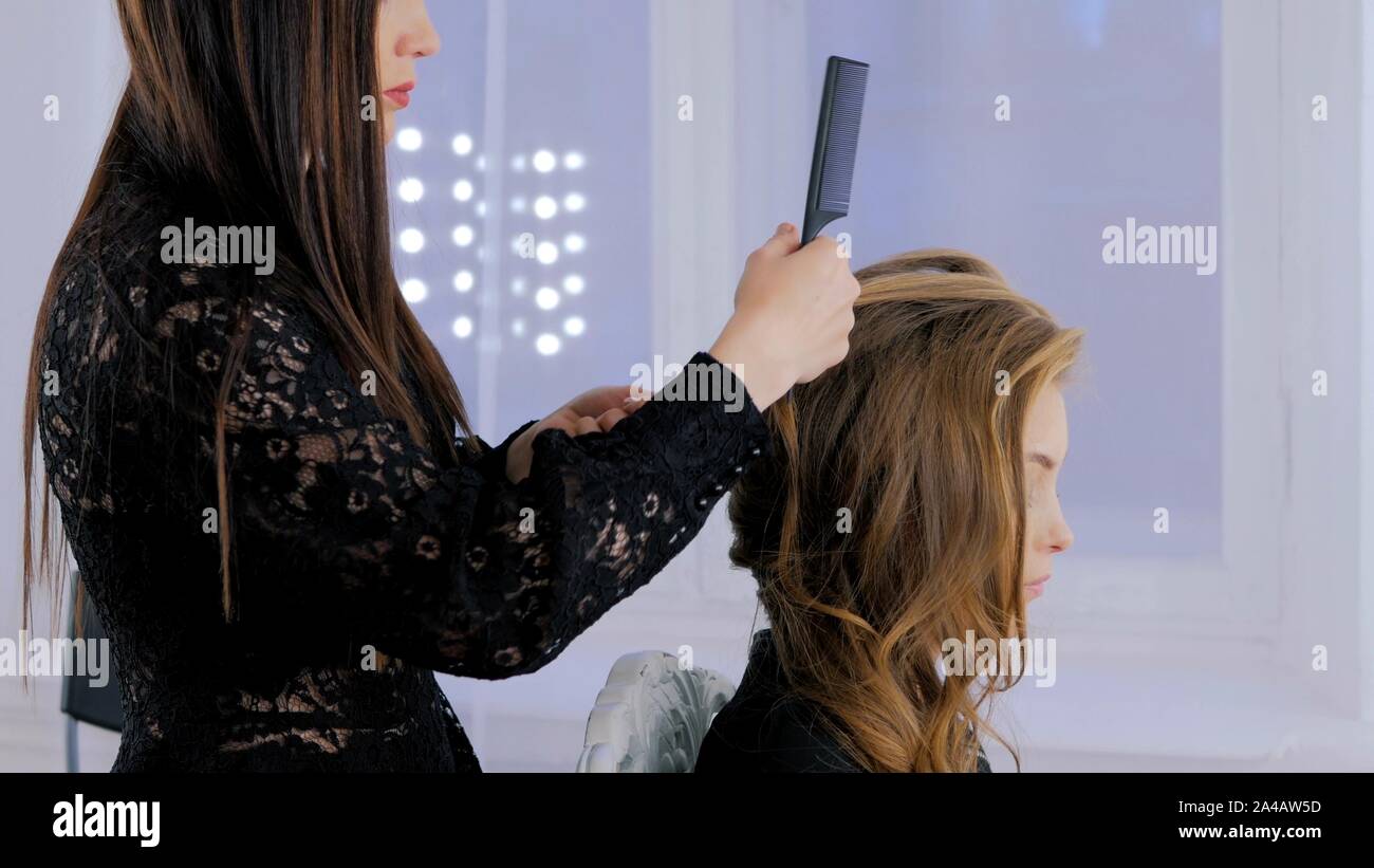 Hairdresser finishing hairstyle for client Stock Photo - Alamy