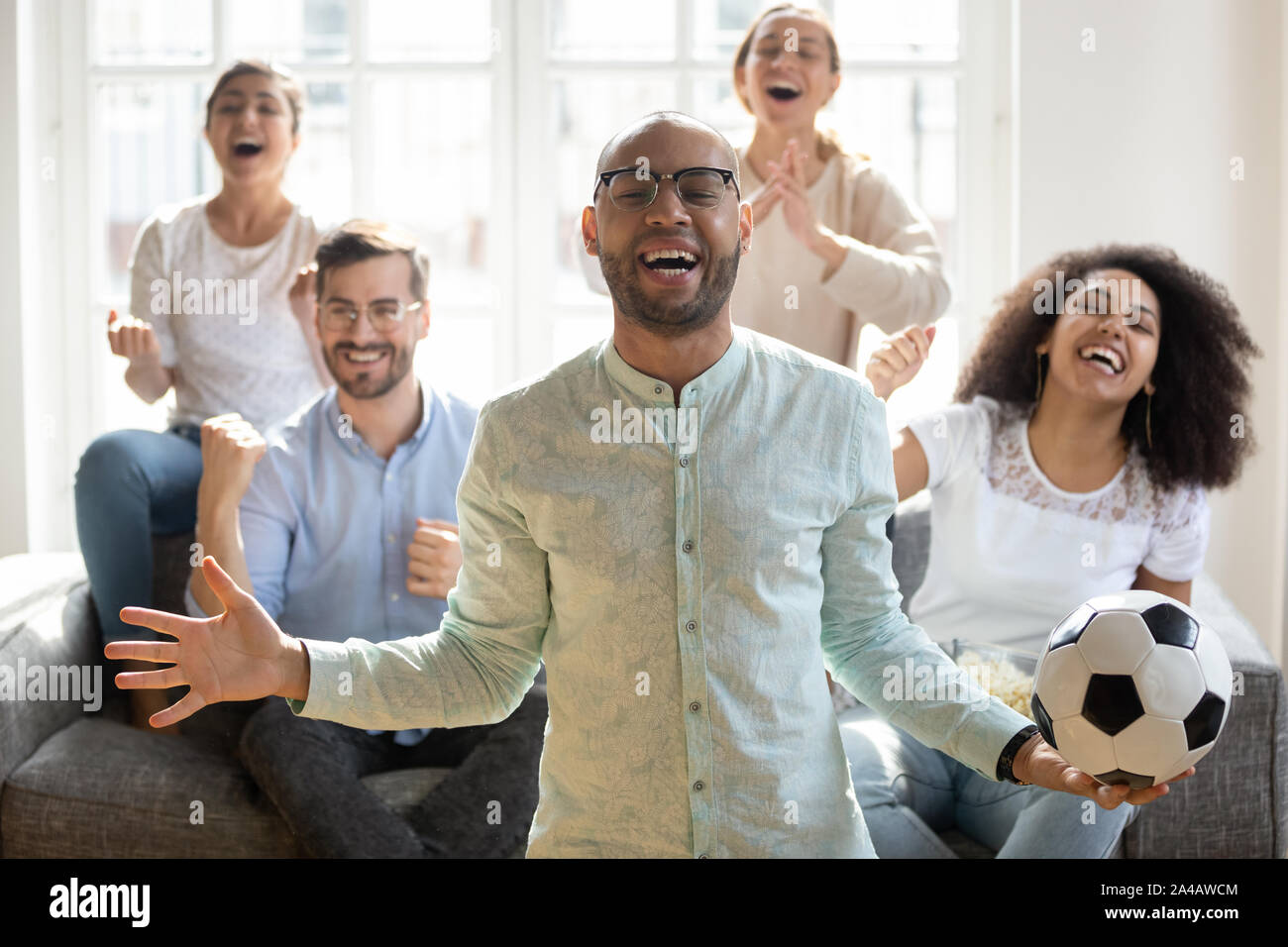 Excited African American man with diverse friends celebrating football ...