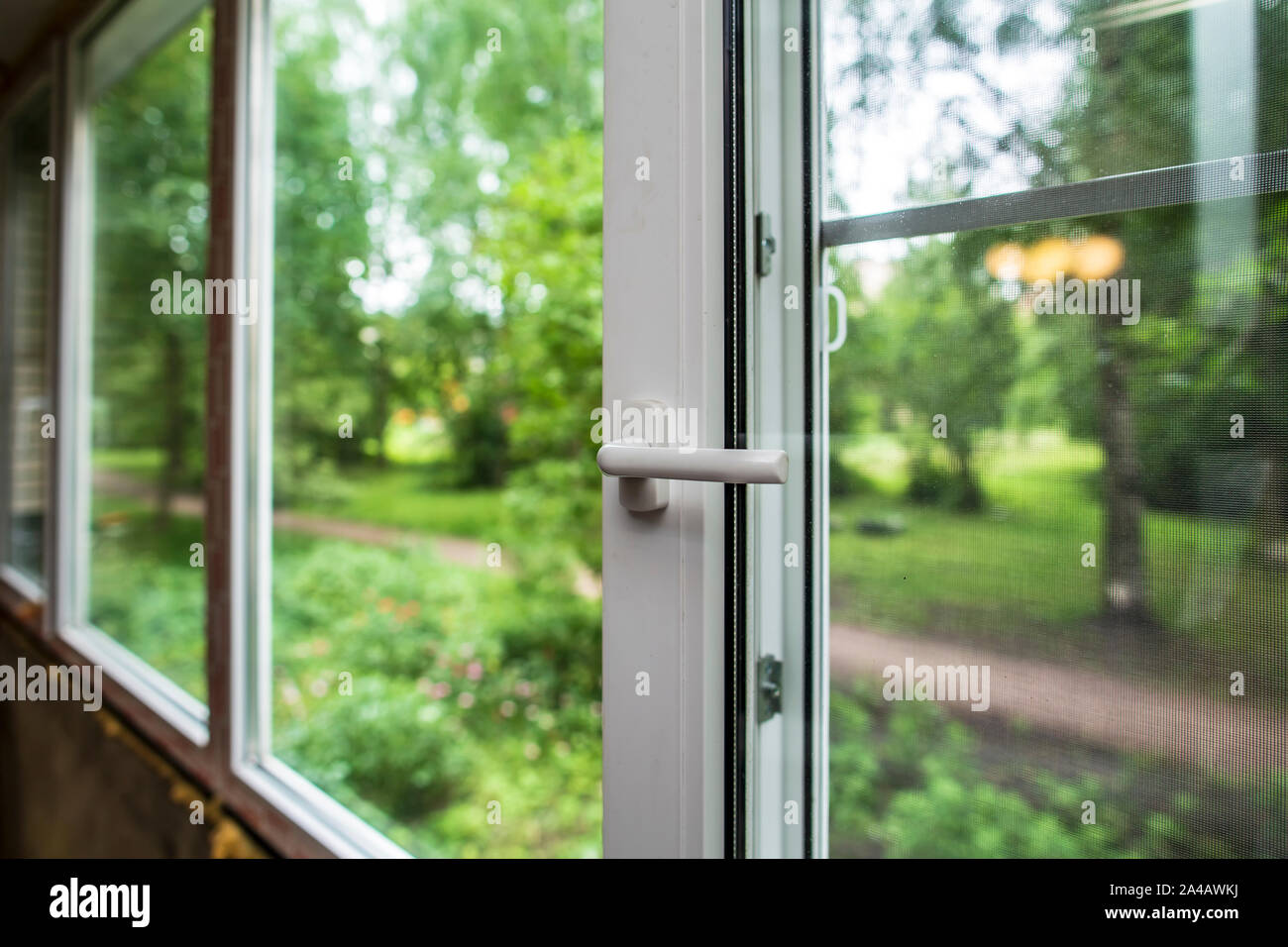 PVC window with mosquito nets, against the background of the yard with ...