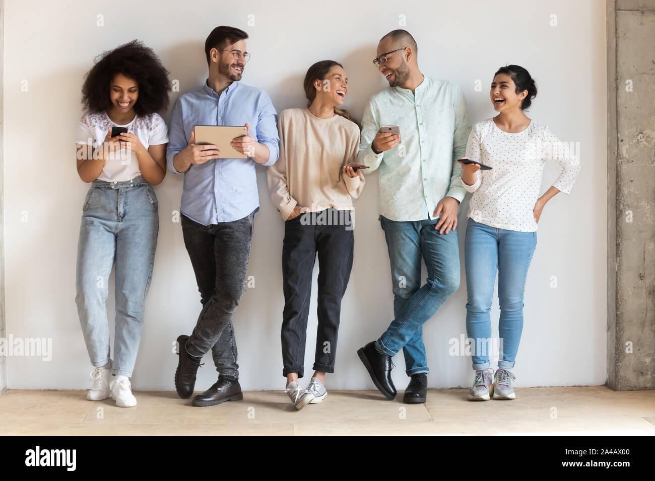 Happy diverse people using phones, laughing, having fun together Stock ...