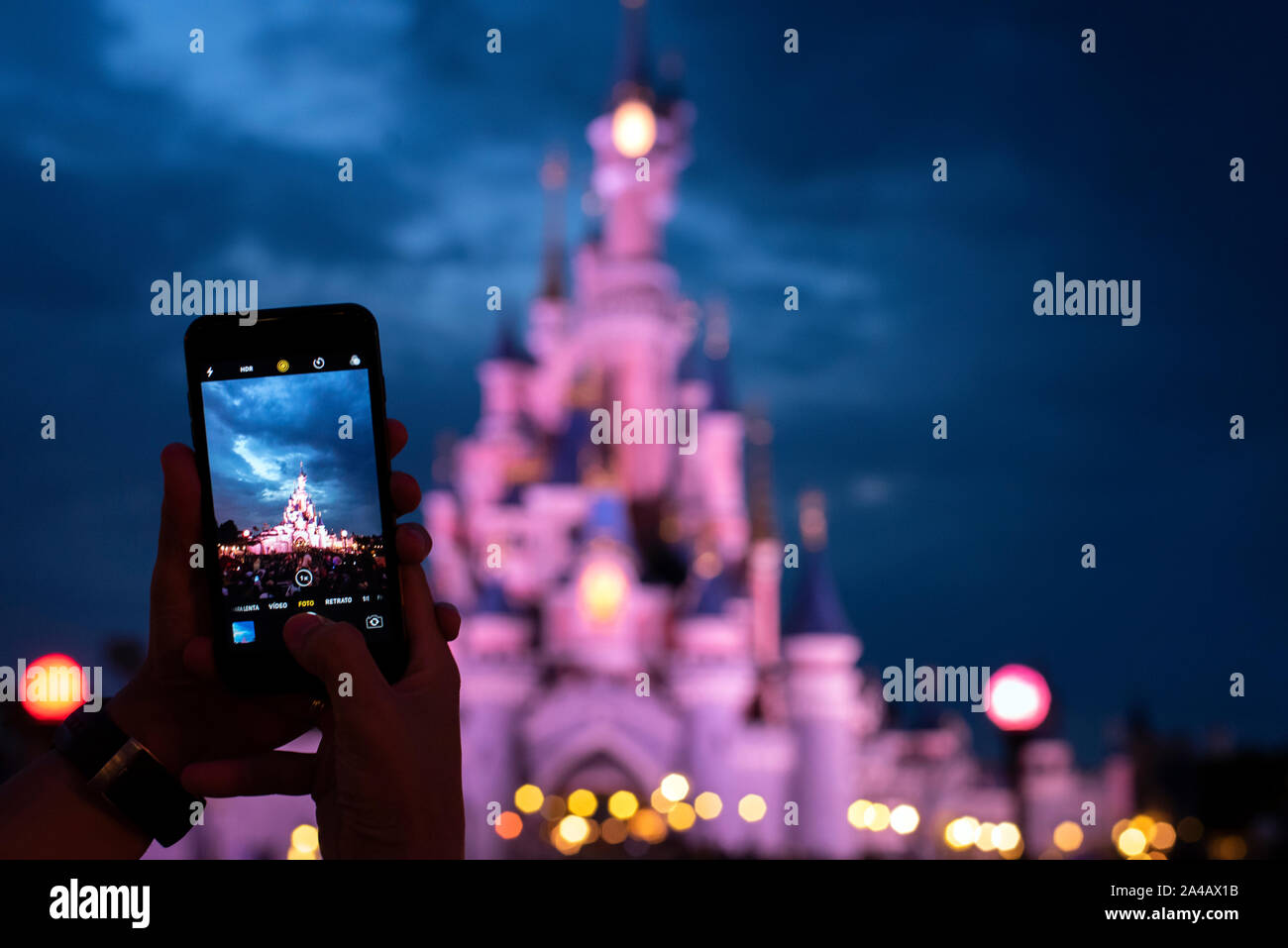 Hands taking a picture of Disney Castle Stock Photo - Alamy