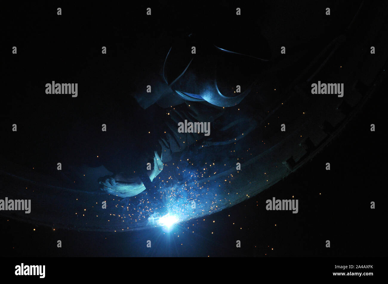 Professional welder welds an industrial tank in a workshop Stock Photo ...