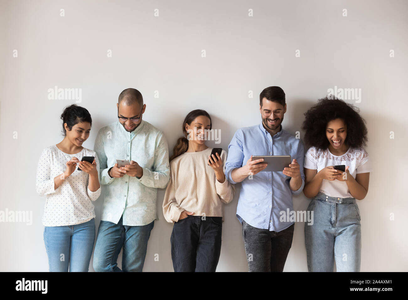 Happy diverse people using electronic devices, standing in row Stock ...