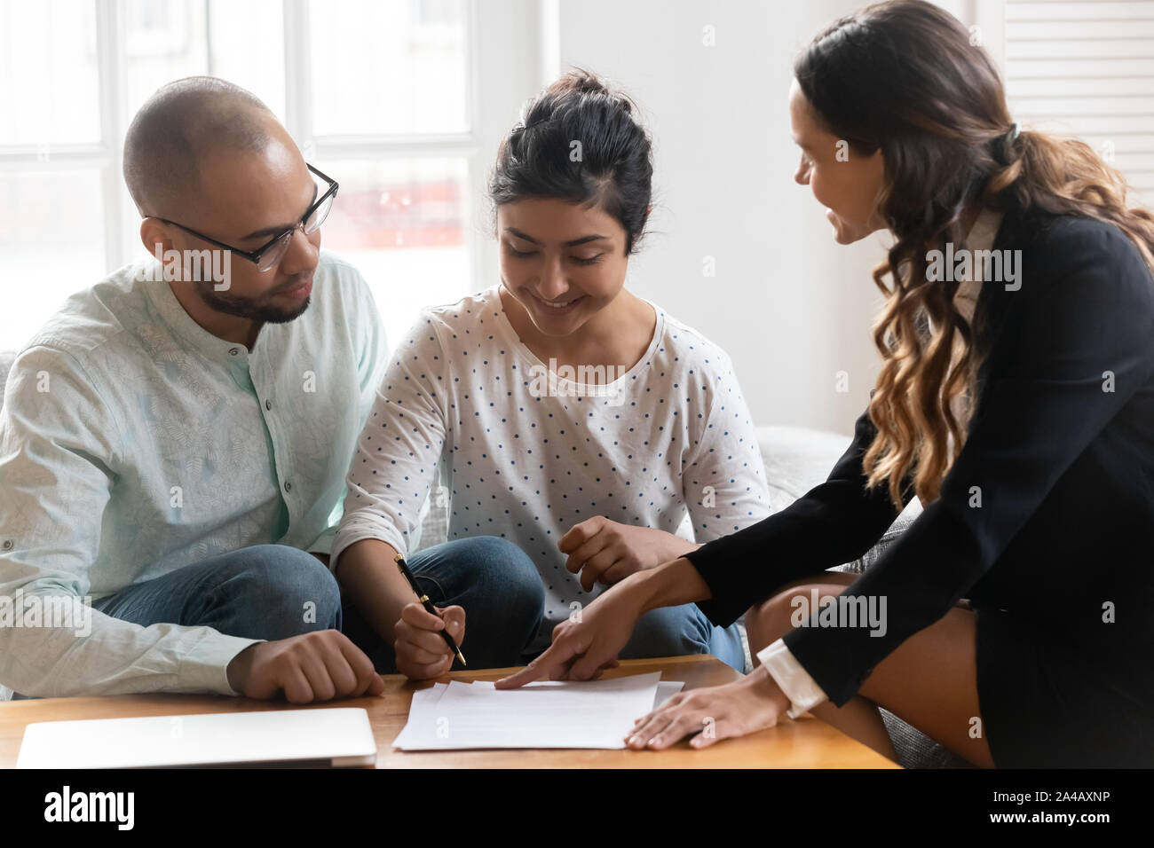 Happy diverse couple making deal, signing contract at meeting Stock ...