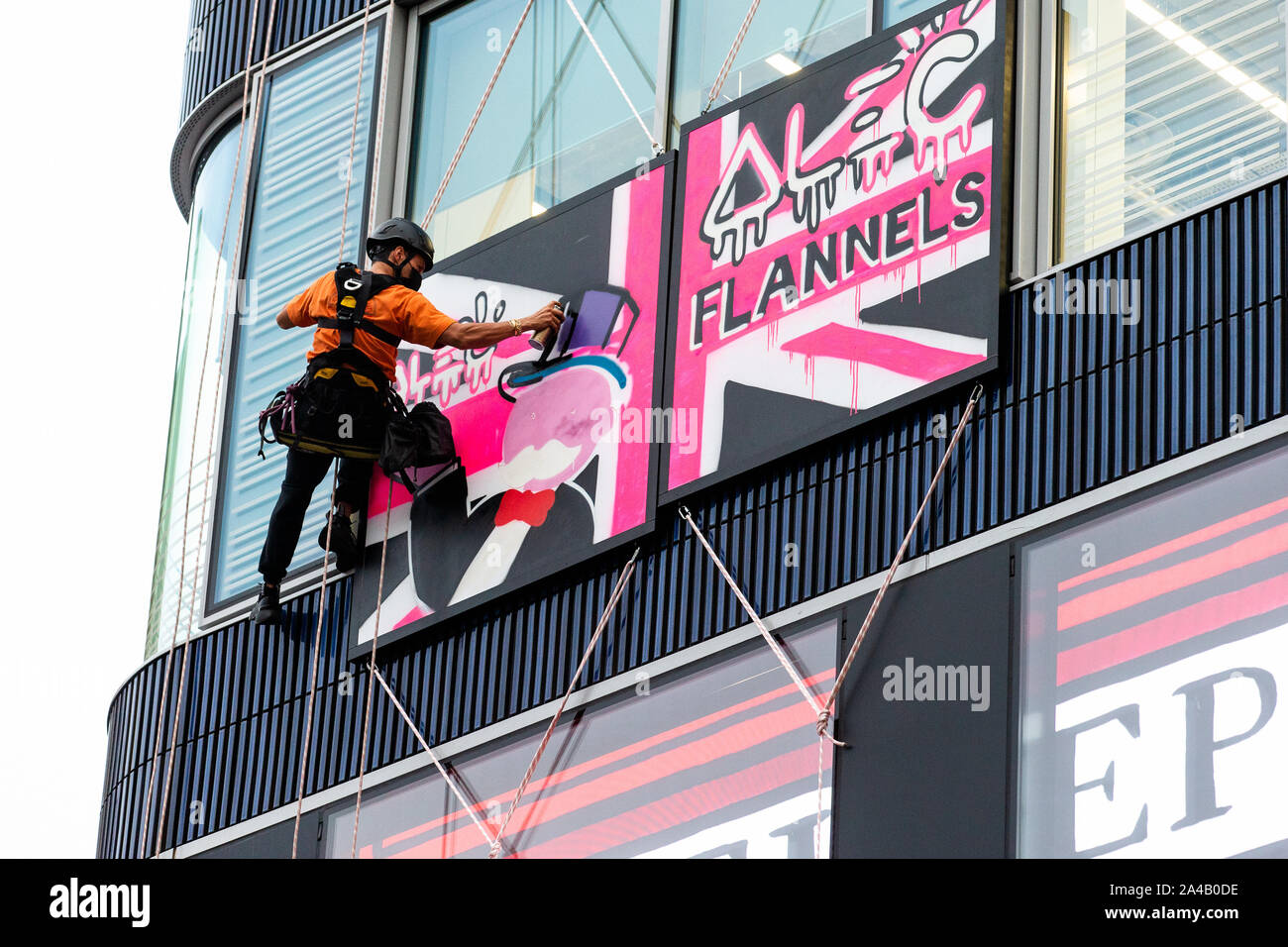 Street artist Alec Monopoly abseils down the Flannels store on Oxford ...