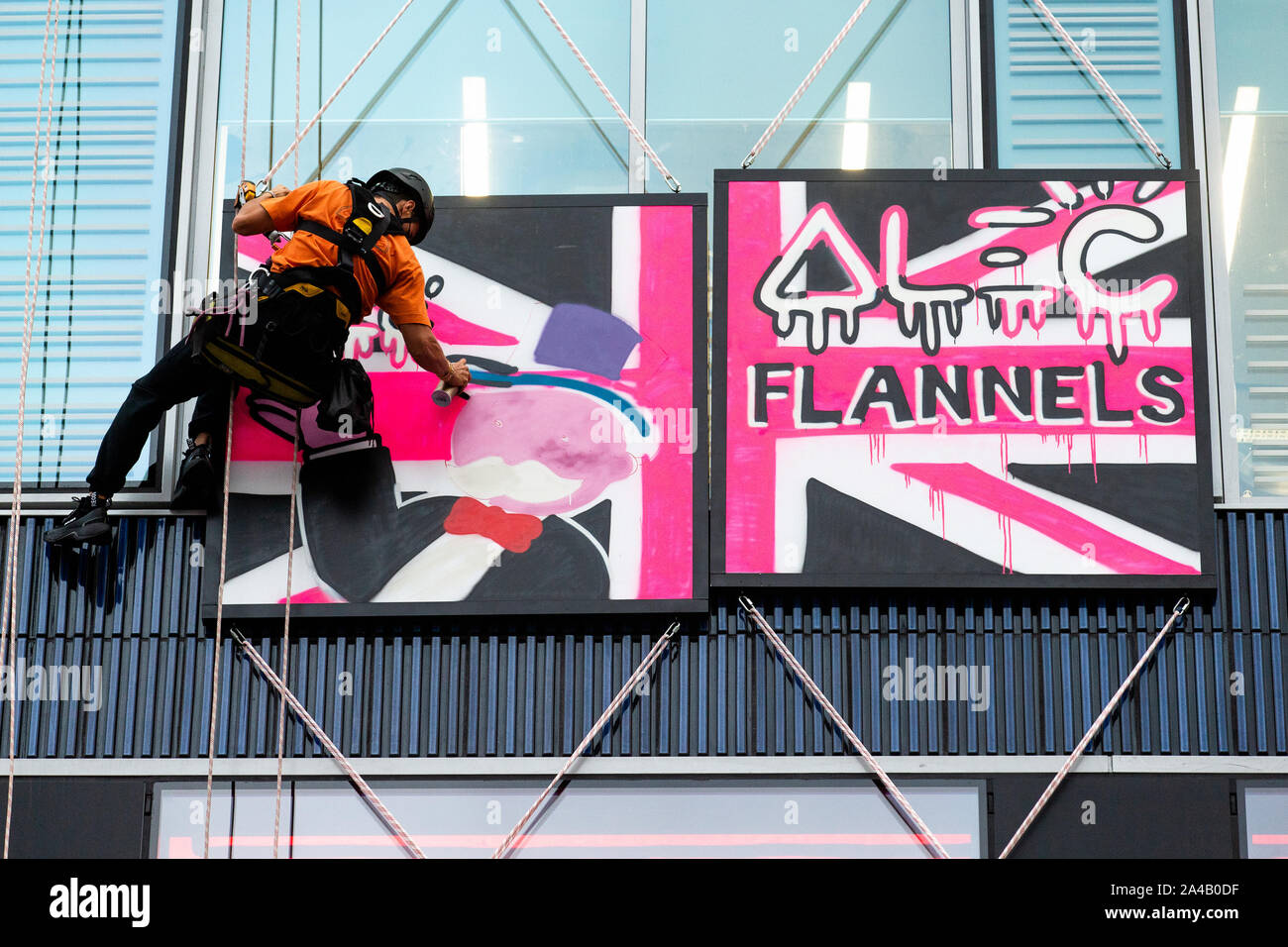 Street artist Alec Monopoly abseils down the Flannels store on Oxford ...