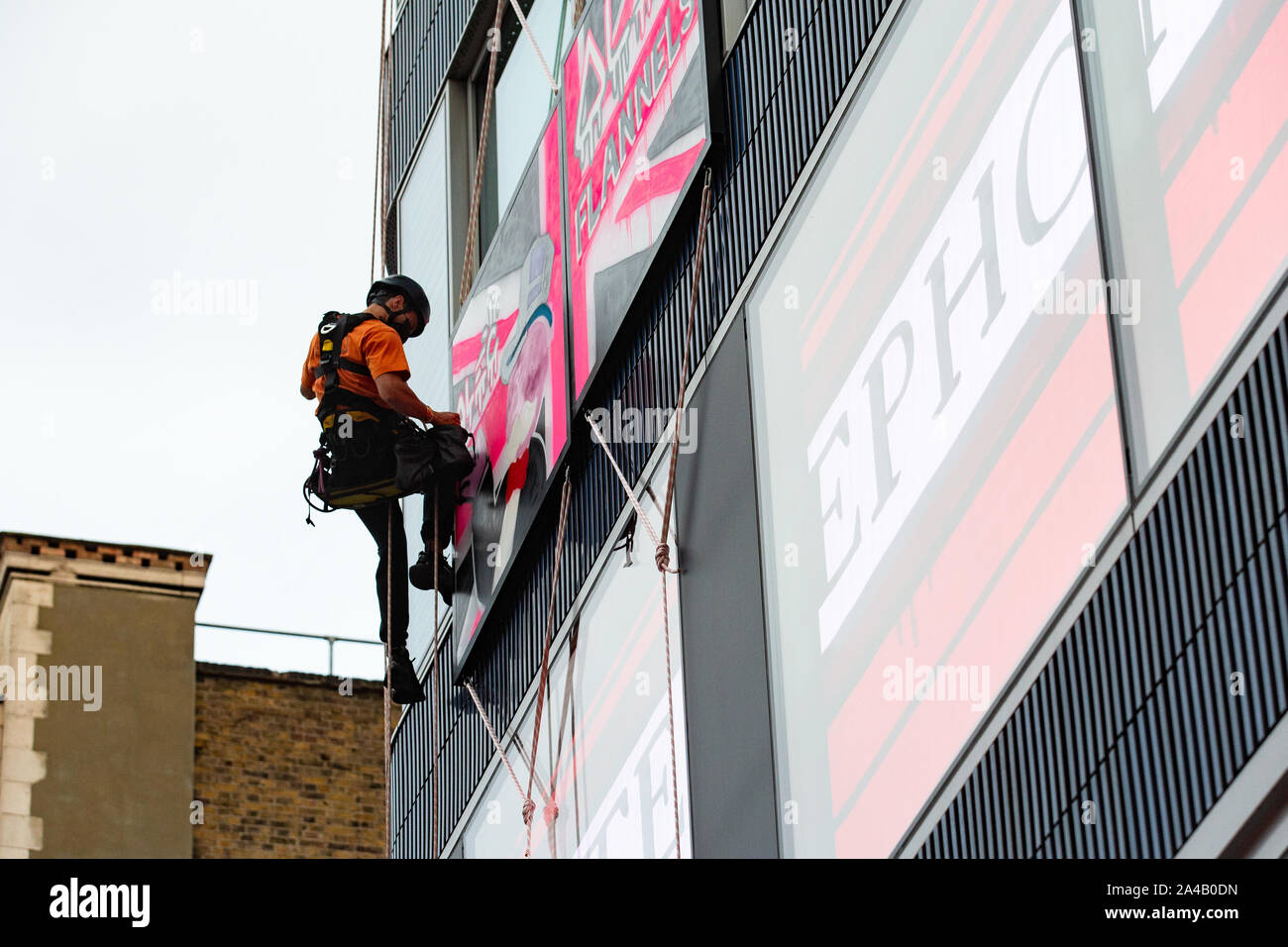 Street artist Alec Monopoly abseils down the Flannels store on Oxford ...