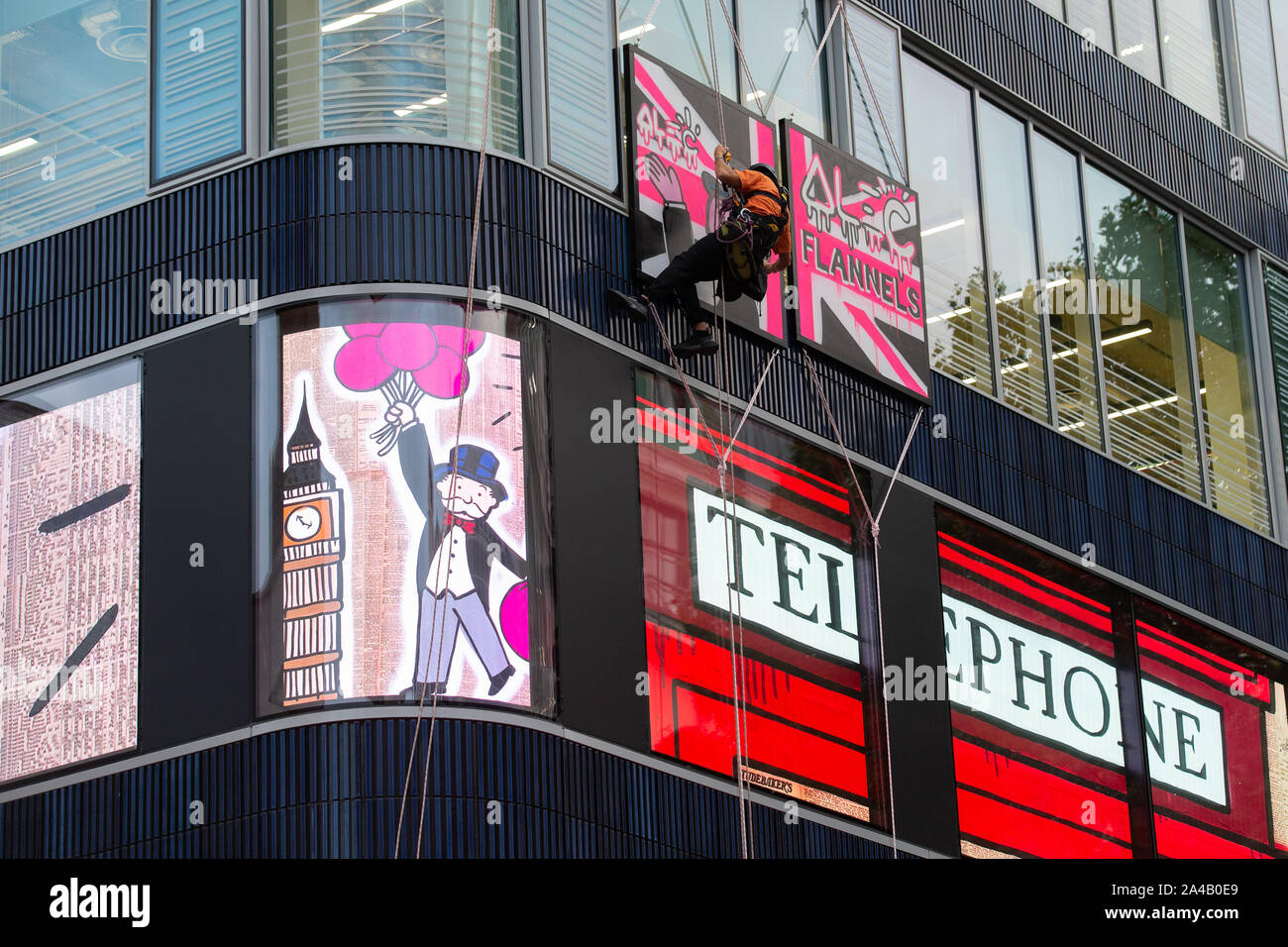 Street artist Alec Monopoly abseils down the Flannels store on Oxford ...