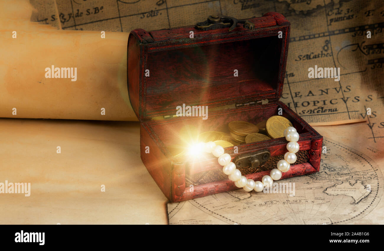 Old pirate chest on vintage maps and scrolls with sparkling treasure ...