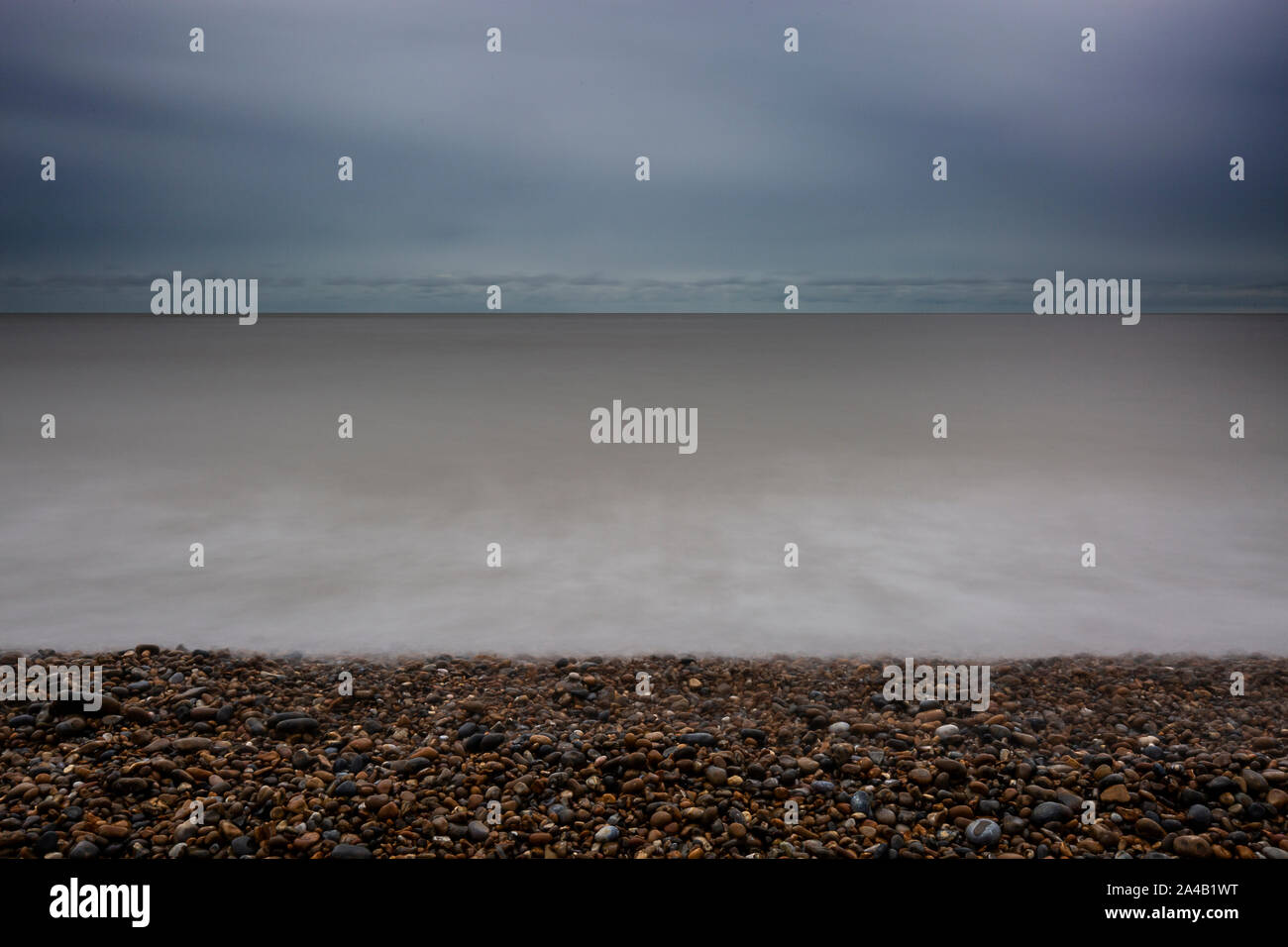 Shingle beach, grey sea, dark sky Stock Photo - Alamy