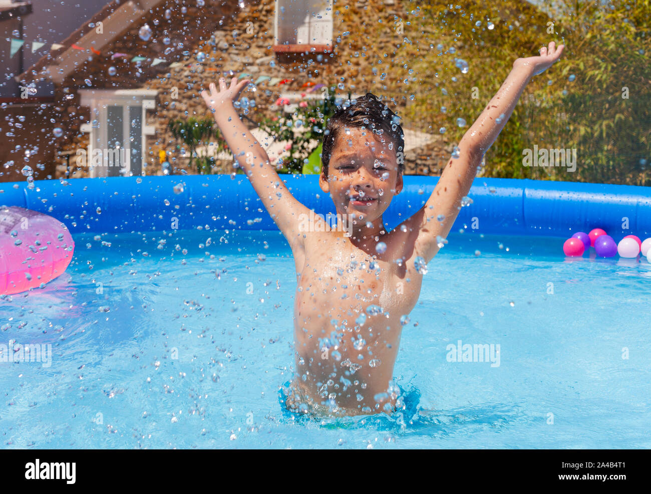 Happy little boy splash water in swimming pool Stock Photo - Alamy