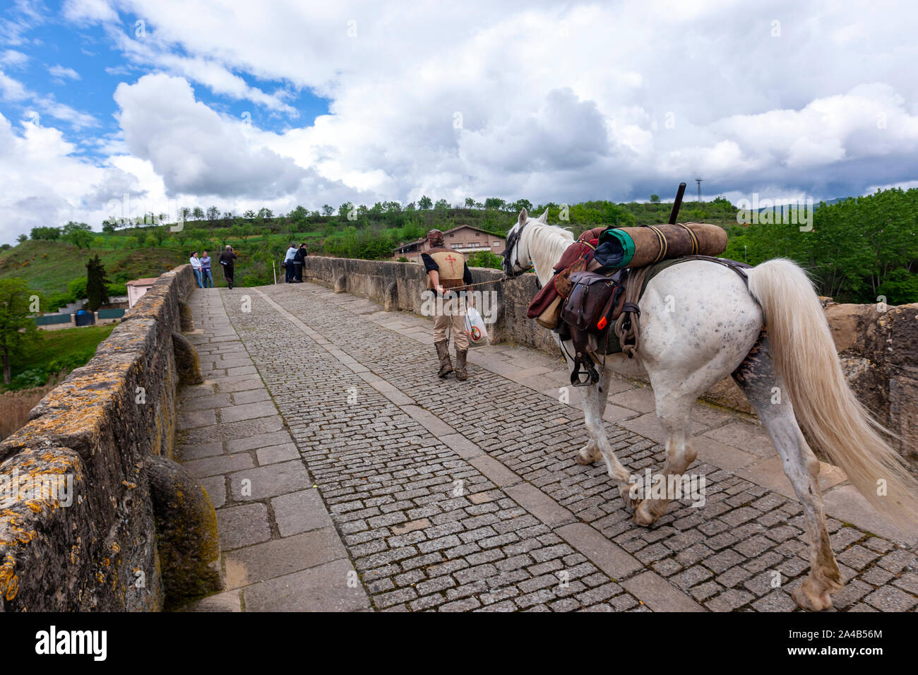 Horse rider pilgrim to Santiago crossing the Roman Bridge over Arga ...