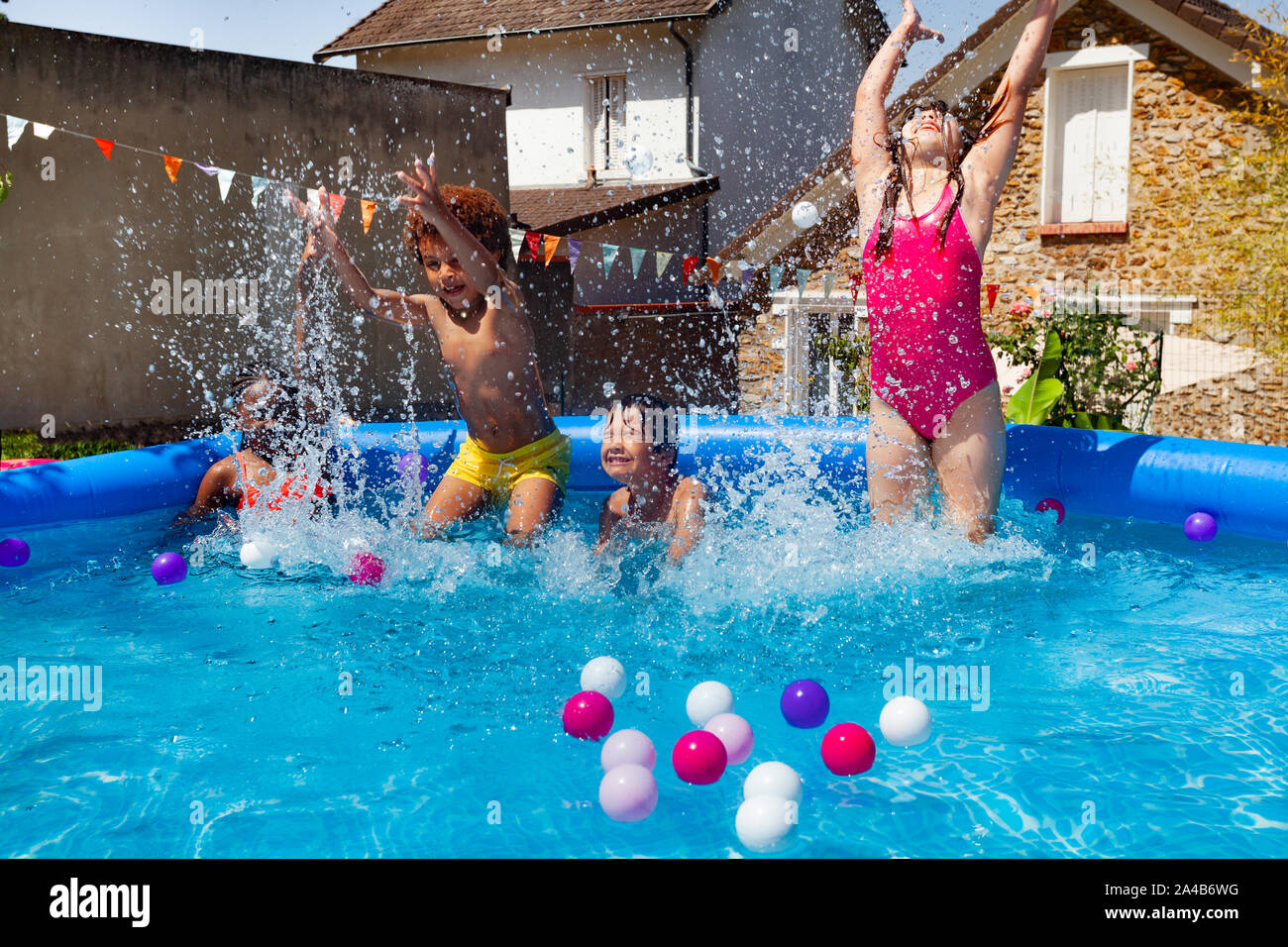 Group of little friends kids splash in pool water Stock Photo - Alamy