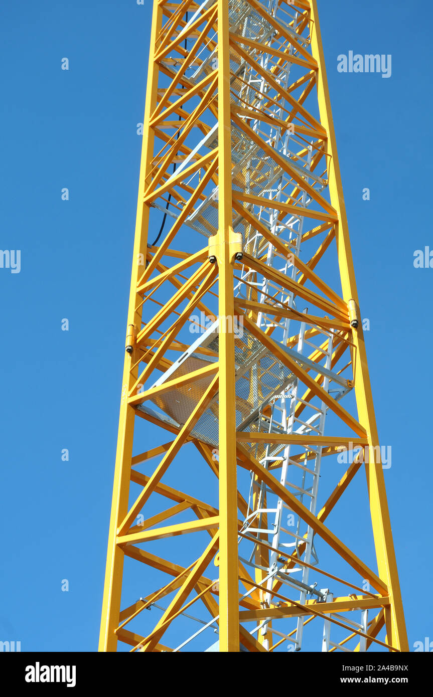 lattice boom of tall construction crane with metal ladder seen from ...